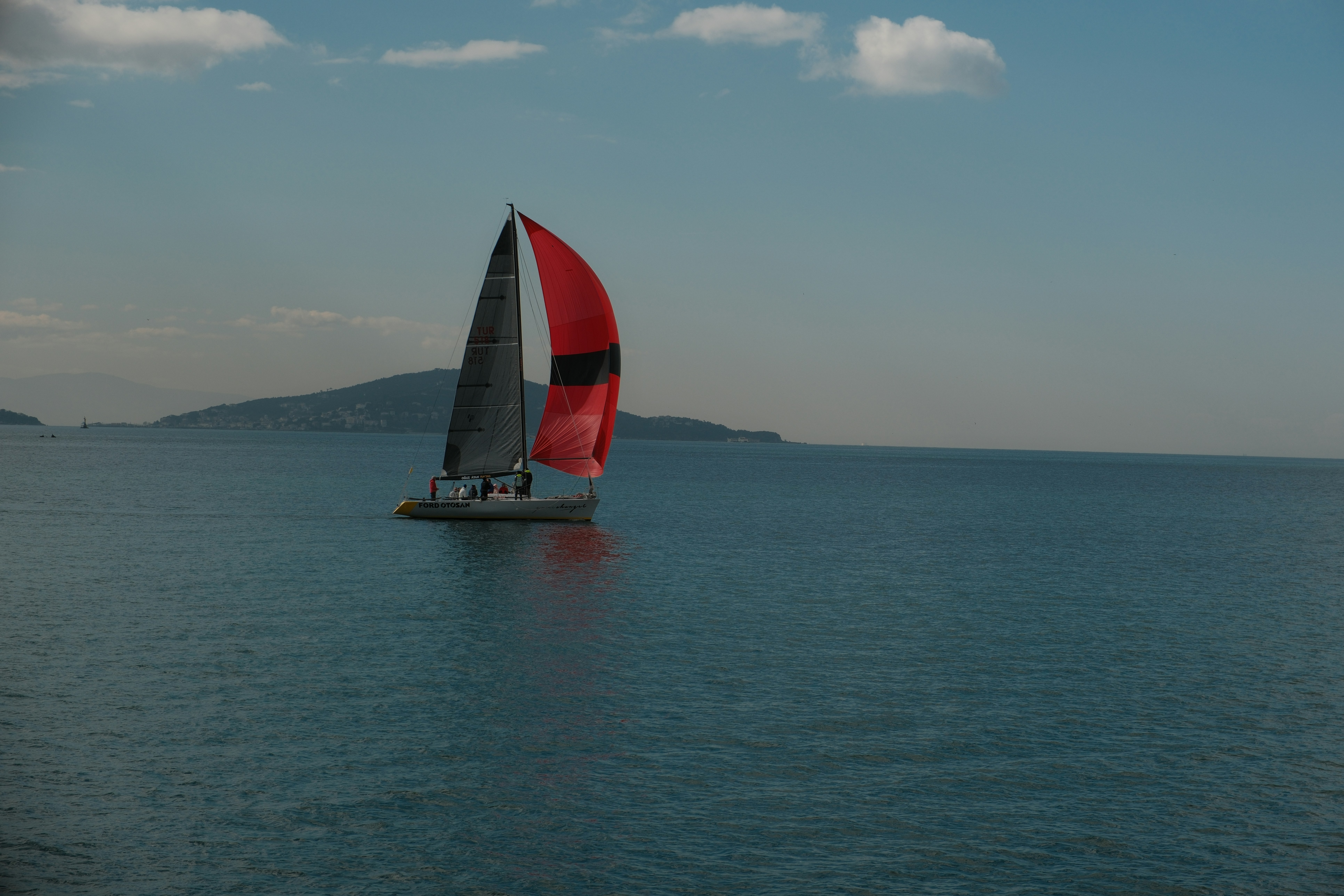 Sailboat Drift: A Red‑Sailed Cruiser on Quiet Open Water