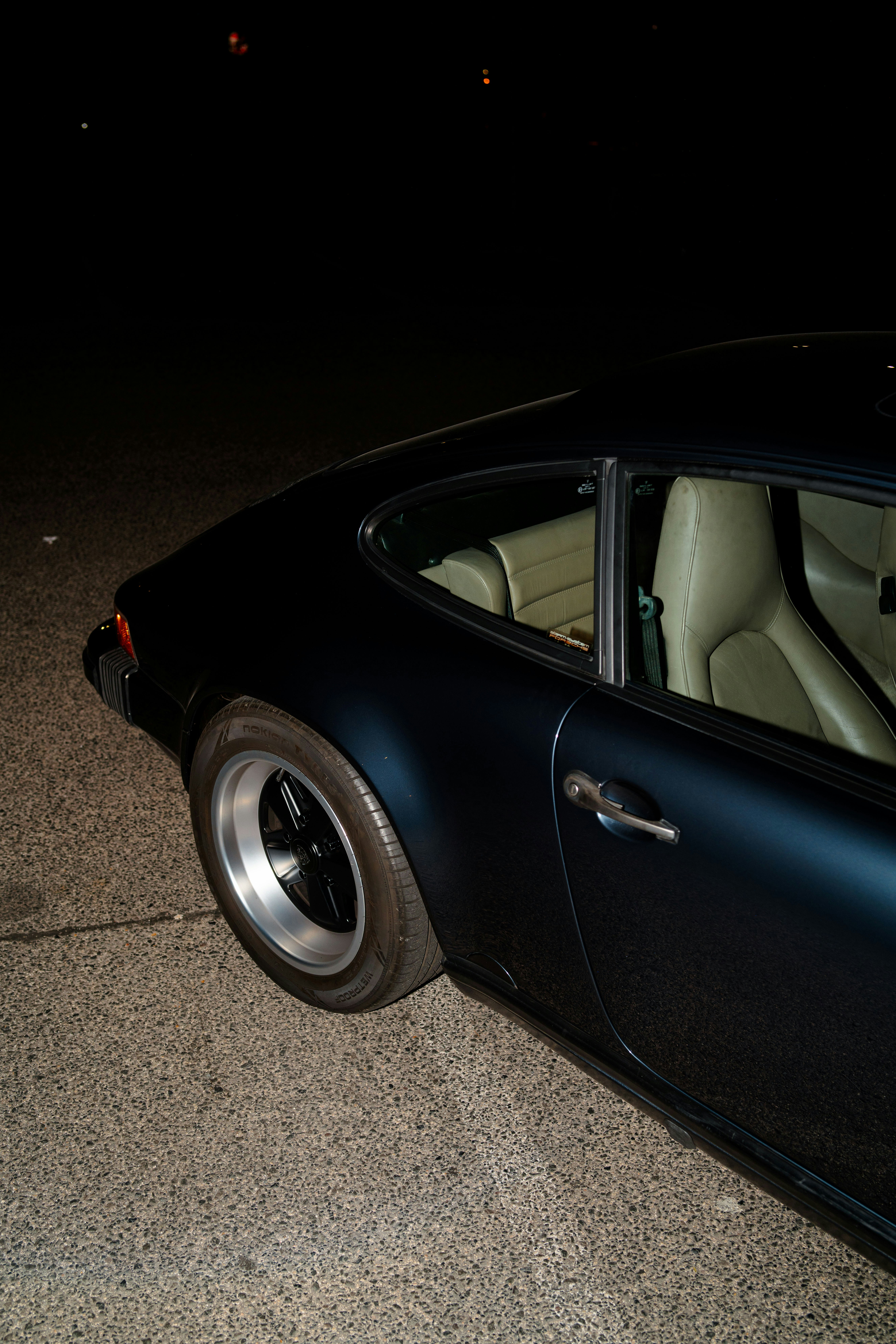 Night Drive: The Silhouette of a Classic Porsche Beneath Streetlights