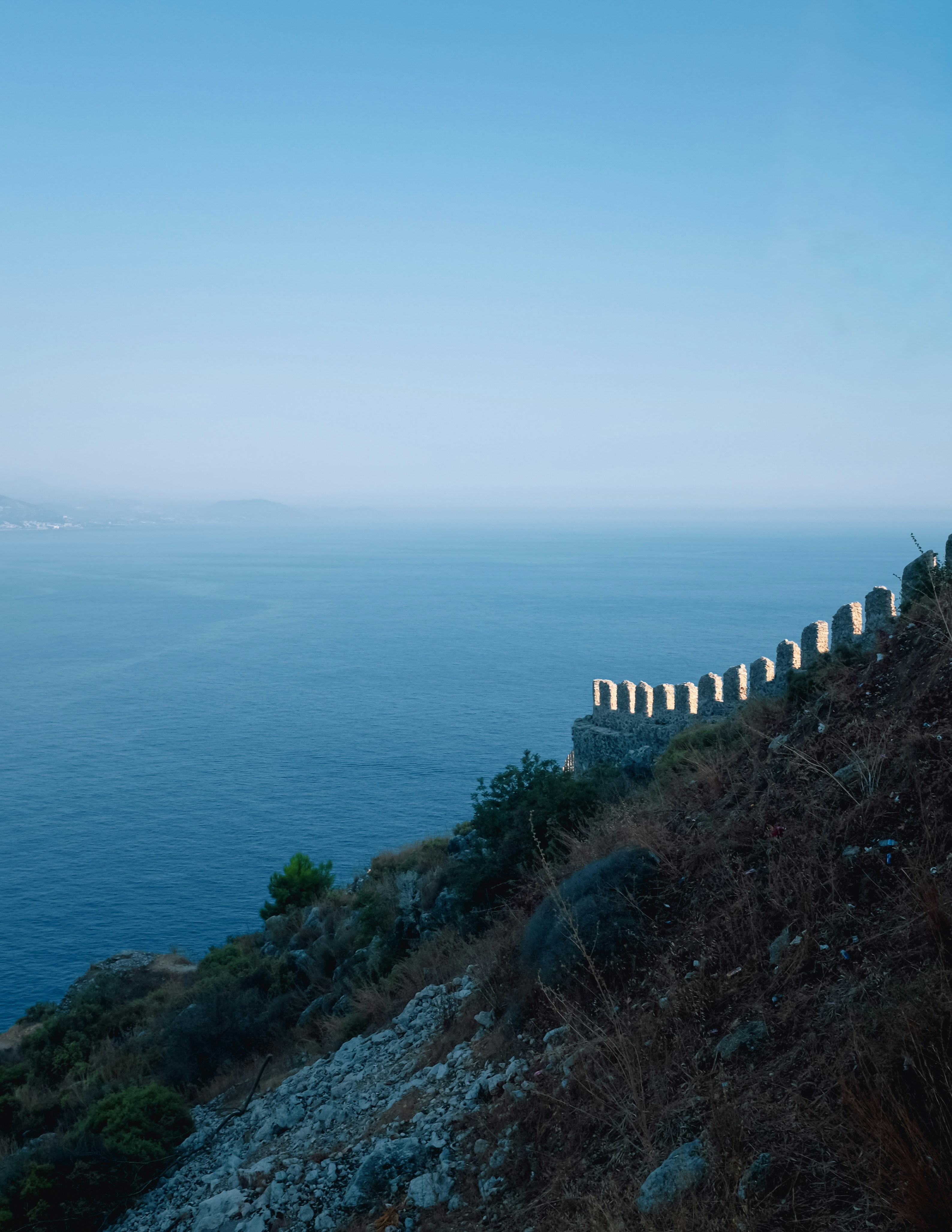 Cliffside Wall Traces the Horizon Over Quiet Blue Seas