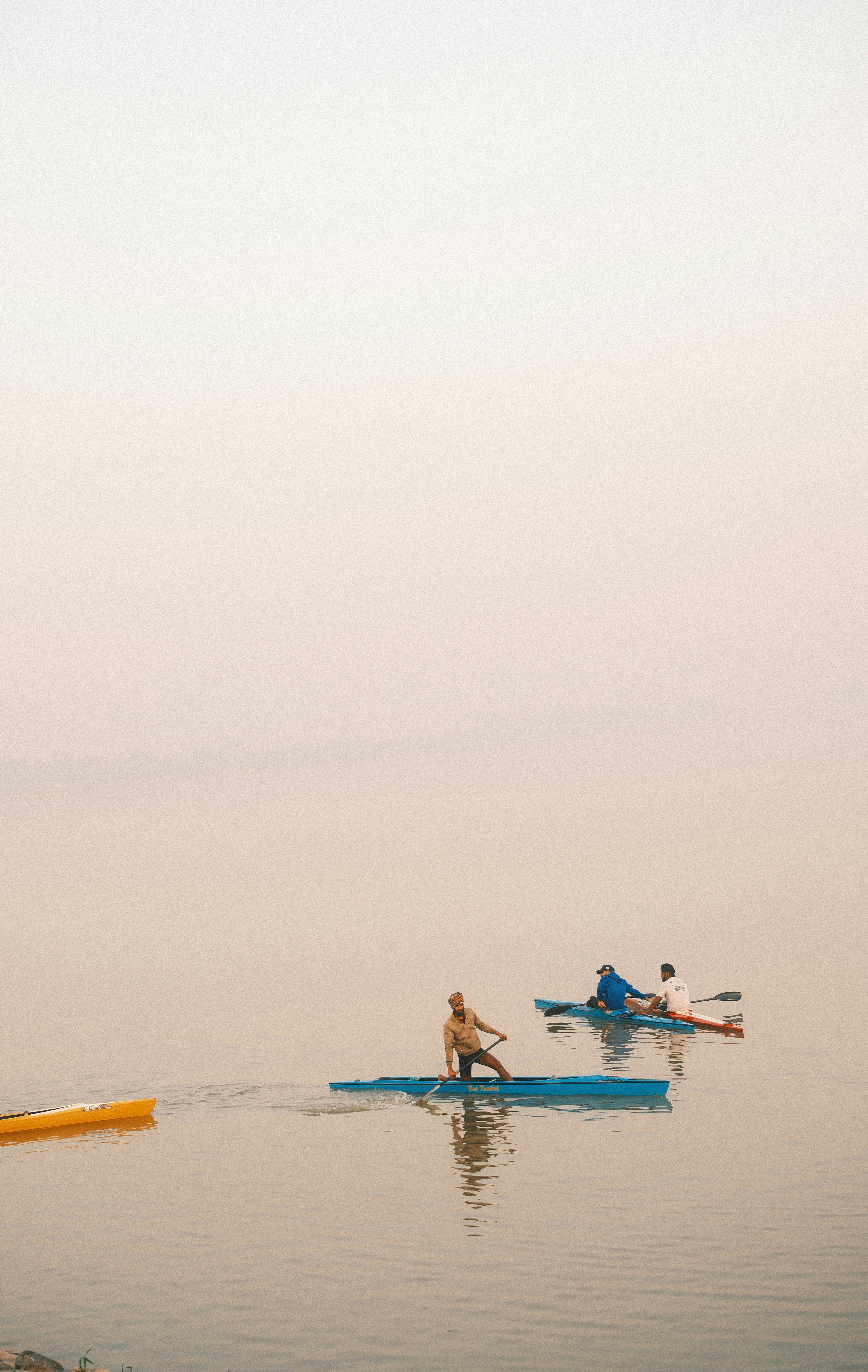 Three Kayaks on a Misty Dawn Lake