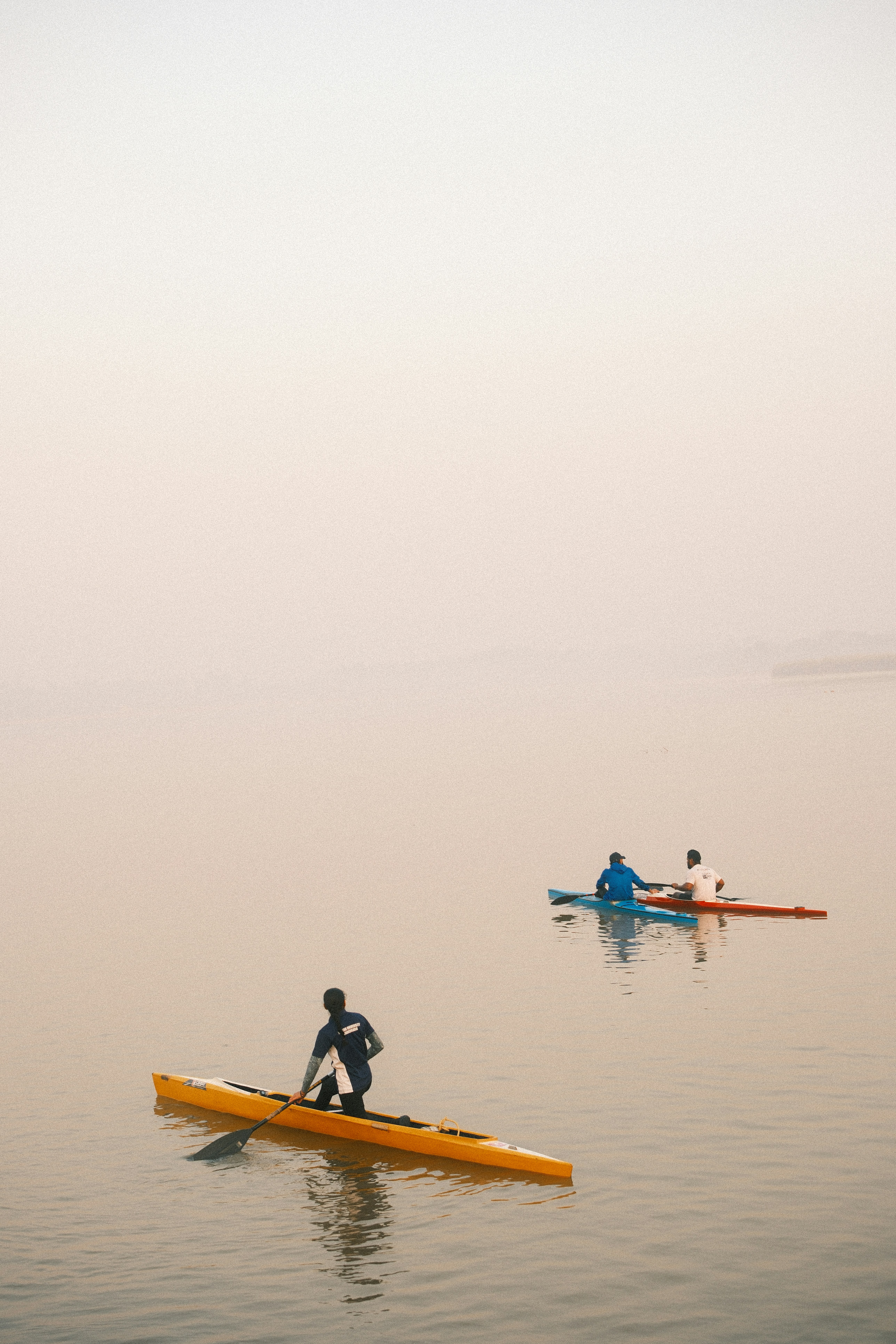 Distant Kayakers on Quiet Glassy Sea at Dusk