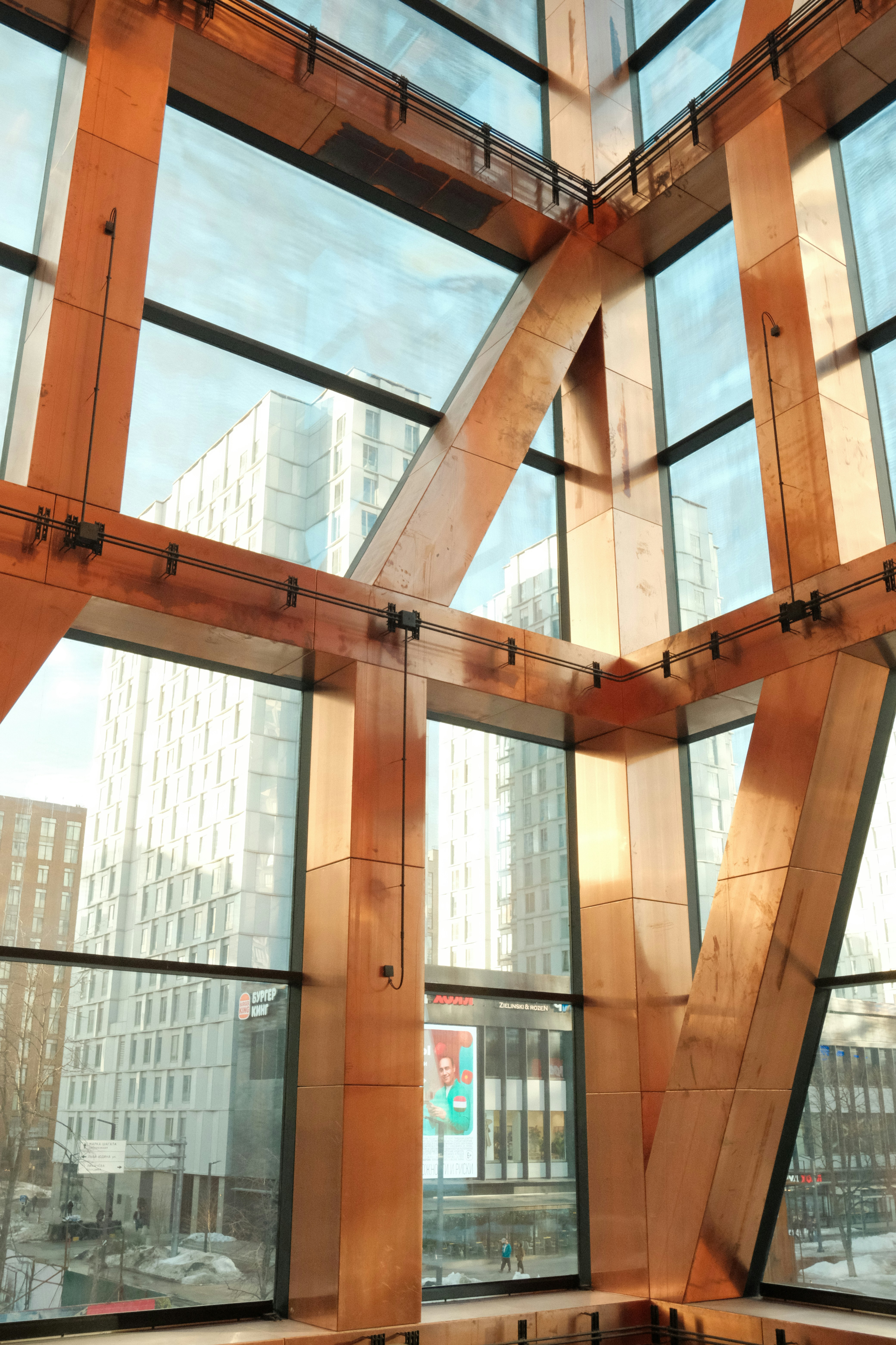 Copper Framework of Glass and Light in Urban Atrium