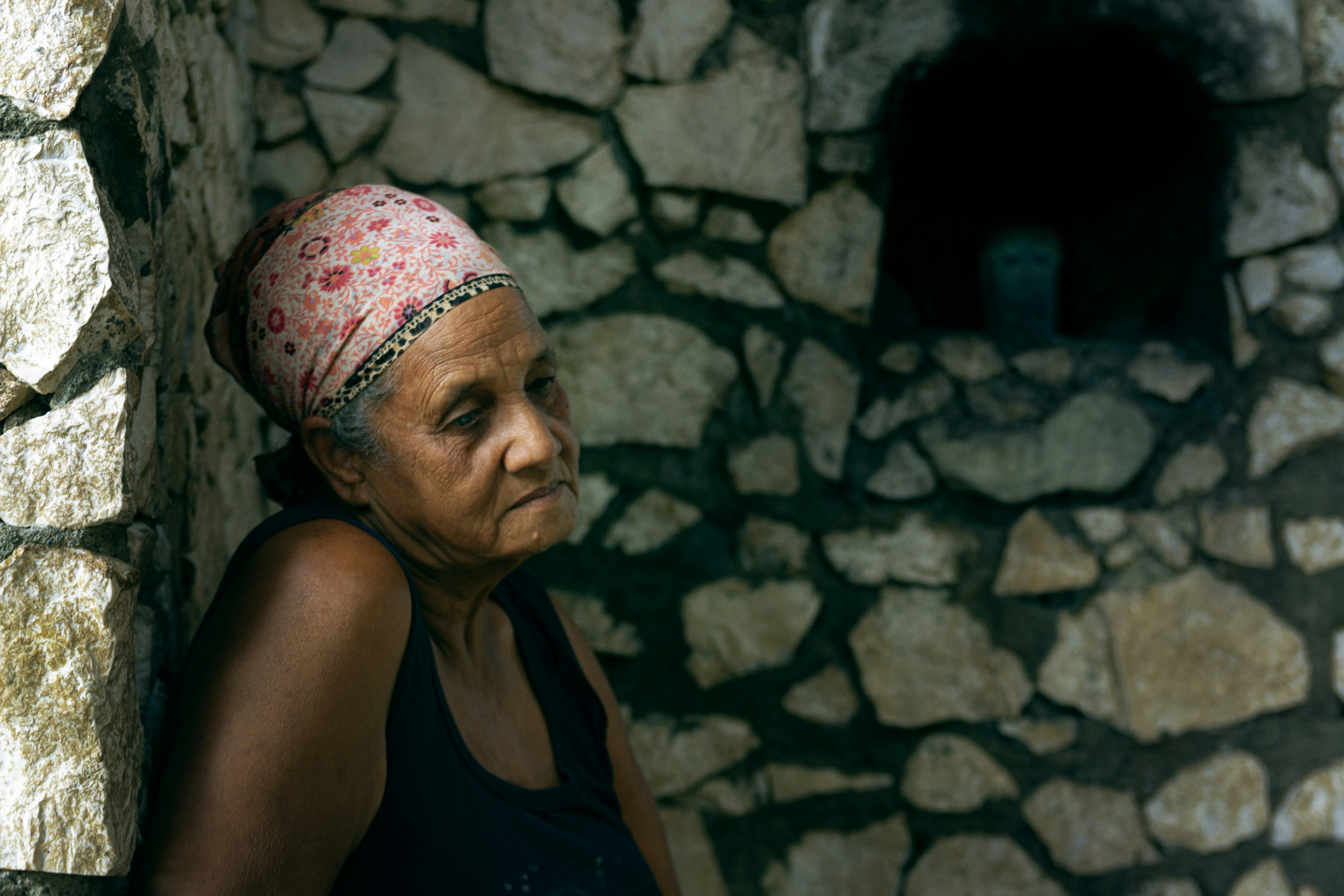 Stone-walled alcove portrait of a reflective elder