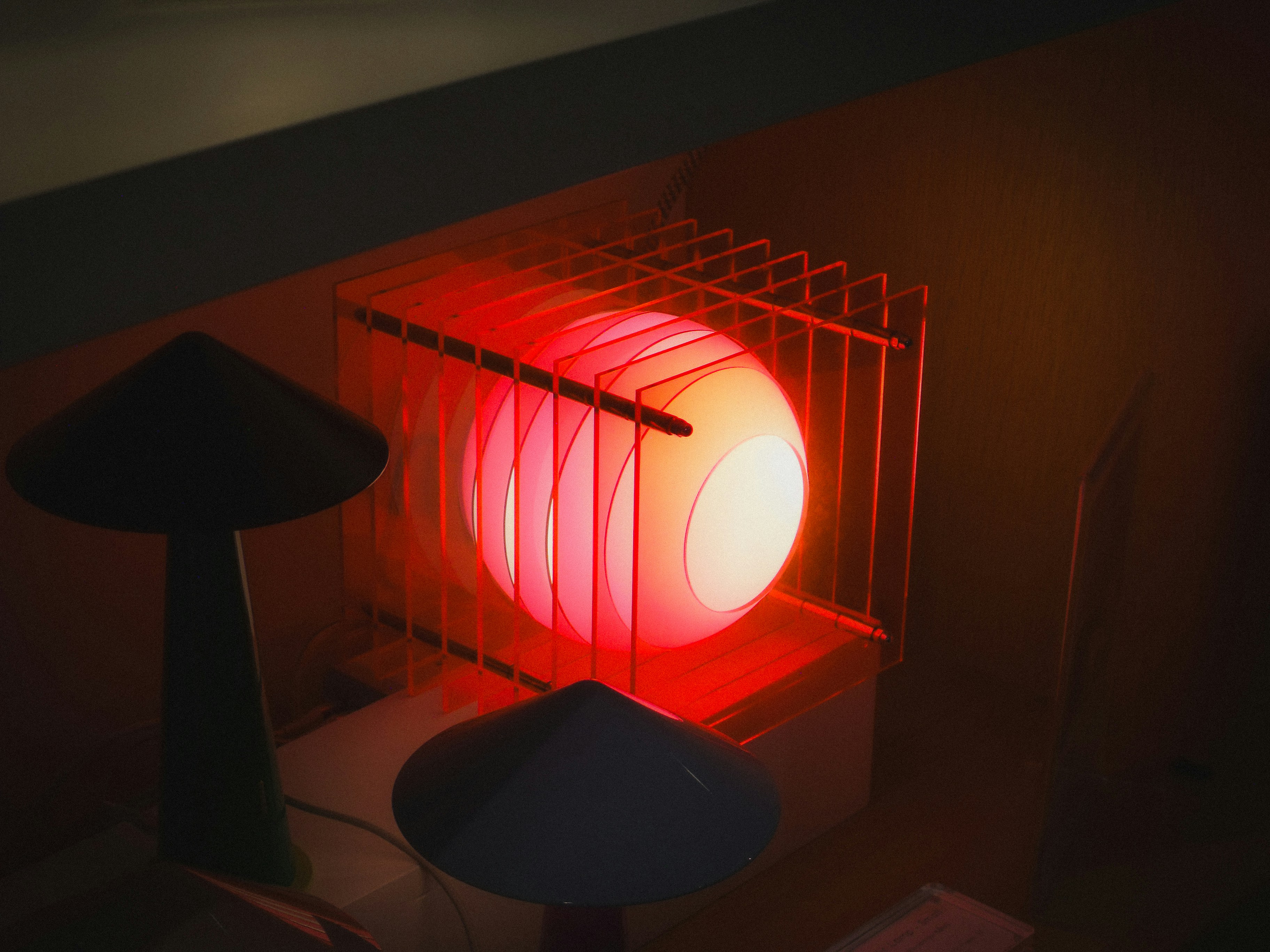 A glowing red orb behind a metal grate