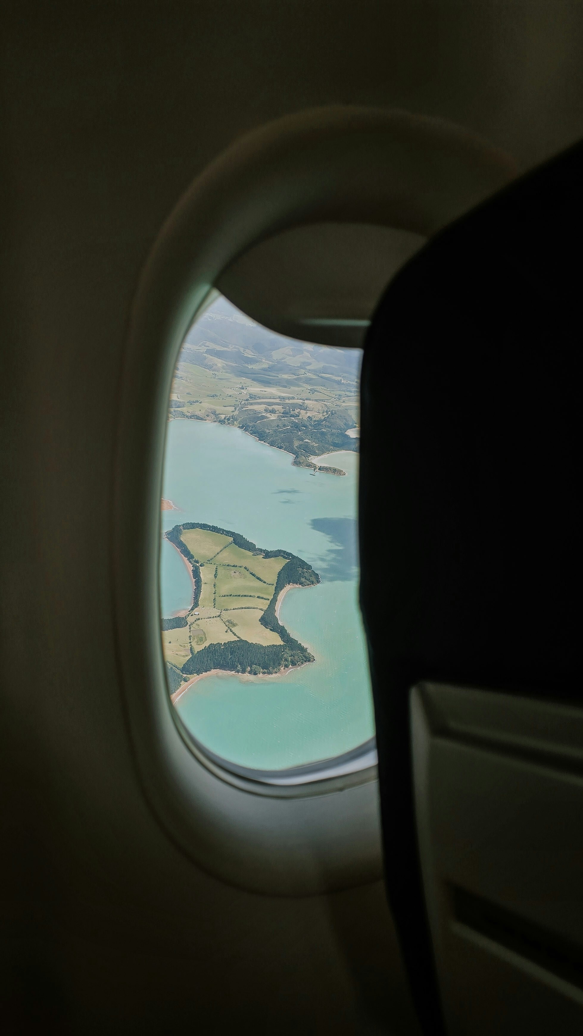 From Window to Fjord: Aerial Coastline Through Oval Frame