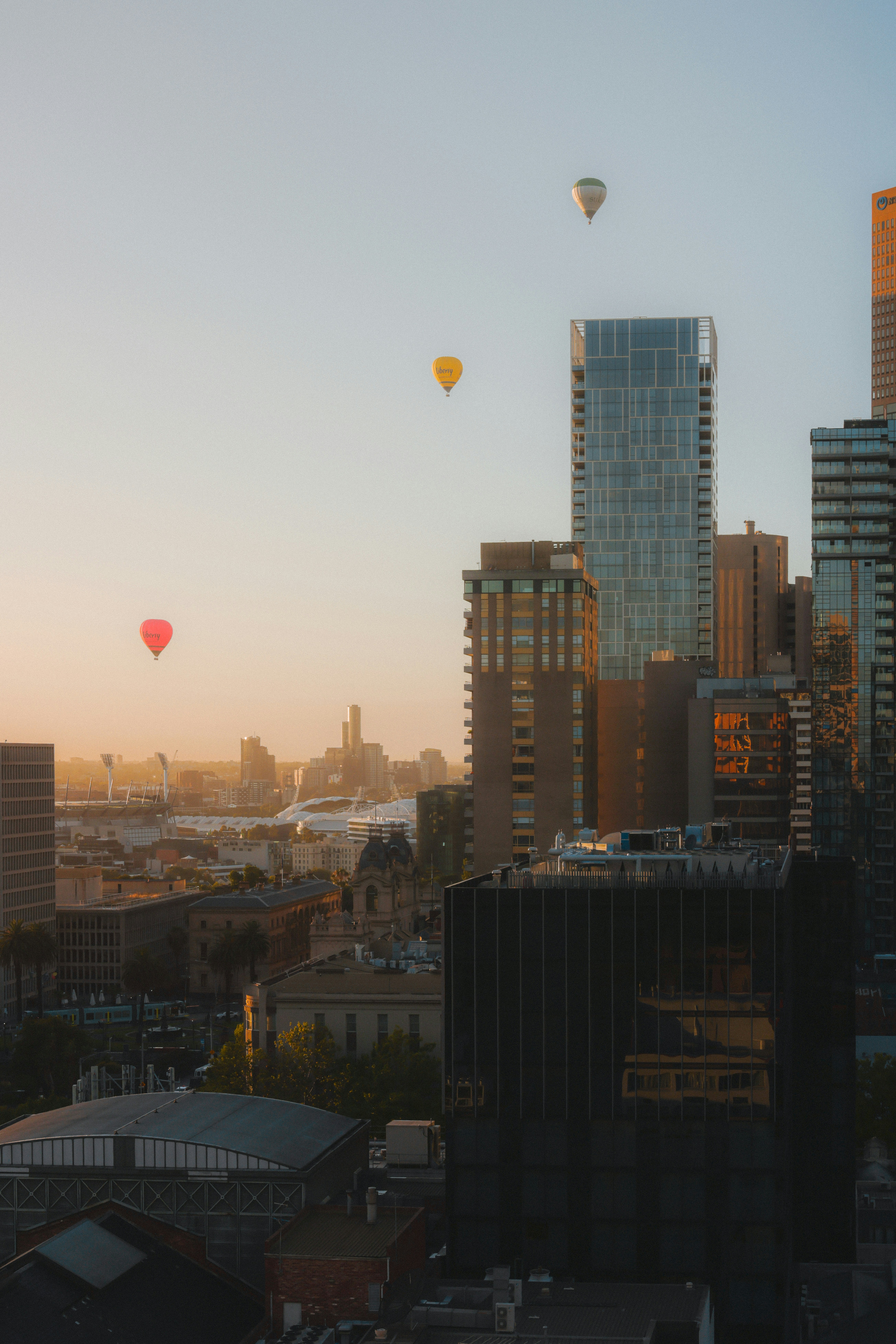 Skyward Ascent: Balloons Above the City at Golden Hour