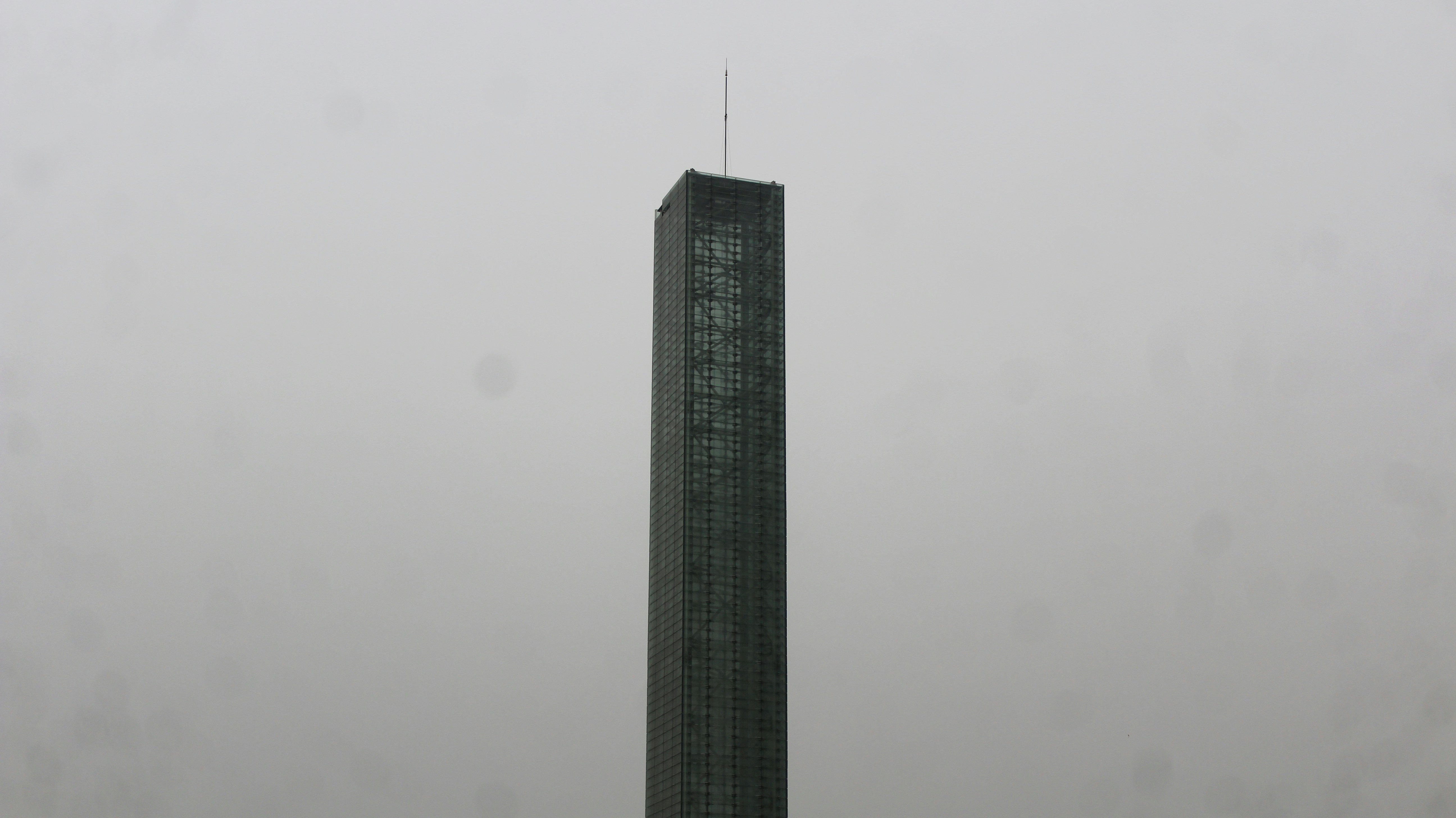 Vertical Sentinel: A Grey Tower Against a Misty Sky