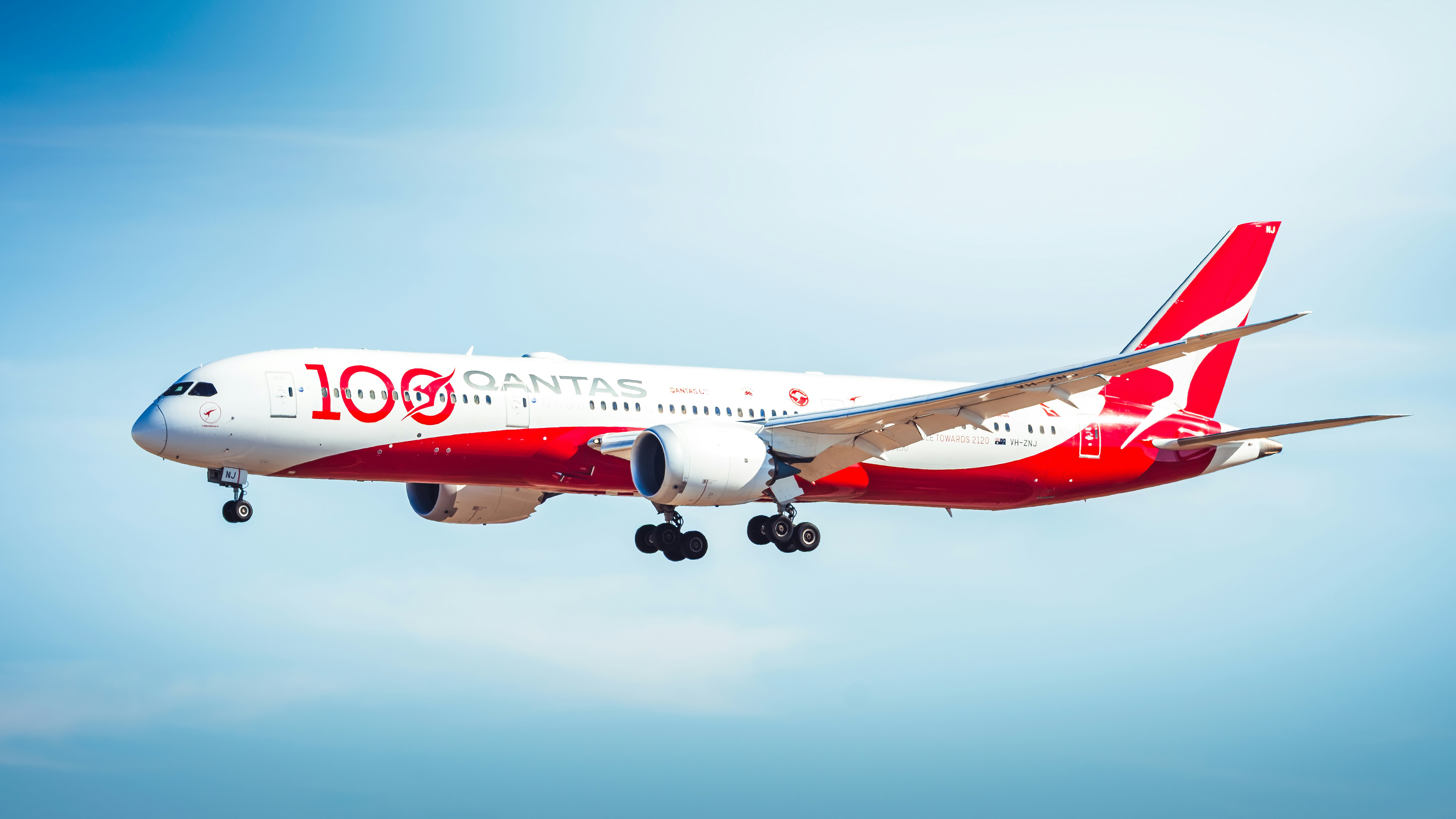 Qantas B777 in Pursuit: A Red-and-White Airliner Threading a Clear Continental Sky