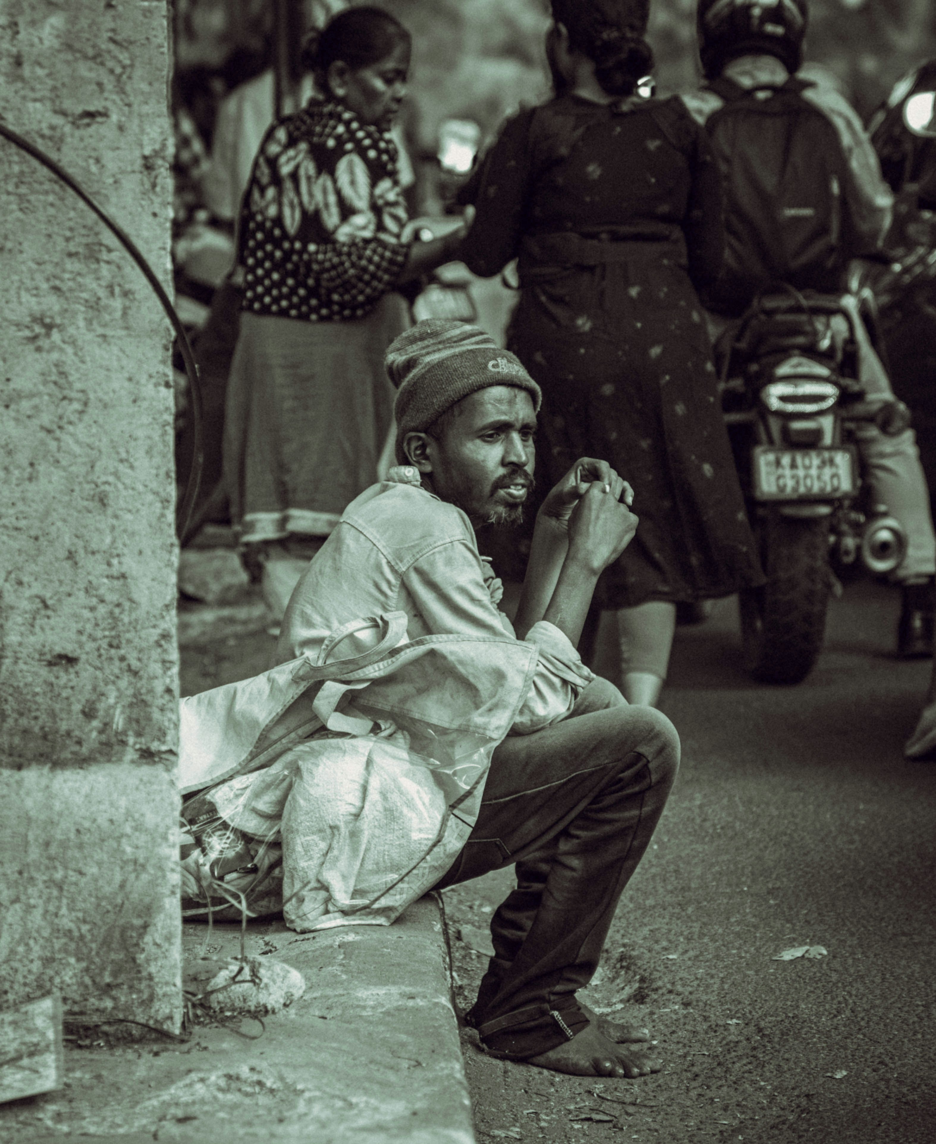 Pause on the curb: a street musician in contemplation amid evening bustle
