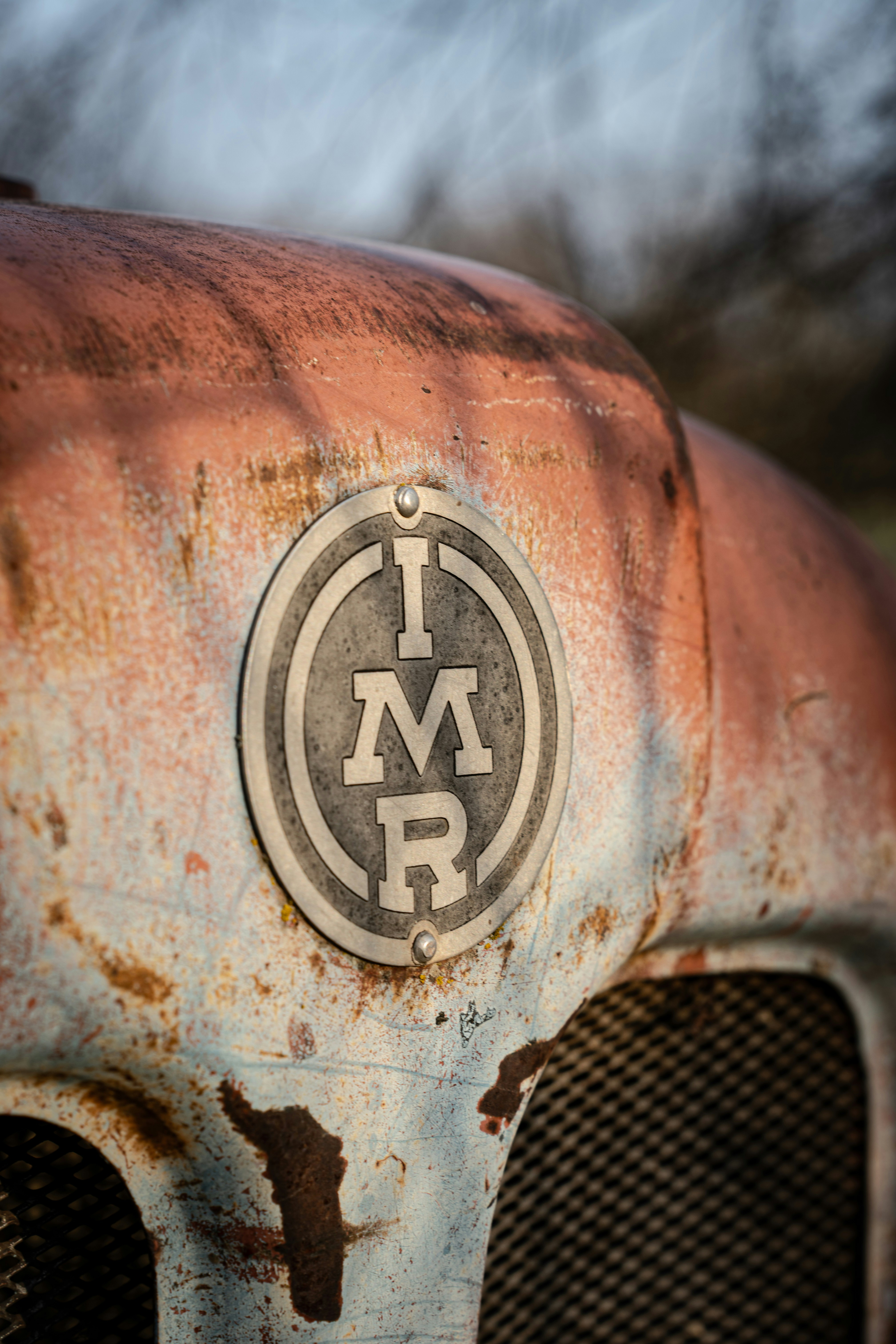 Weathered emblem on rusted vintage grille