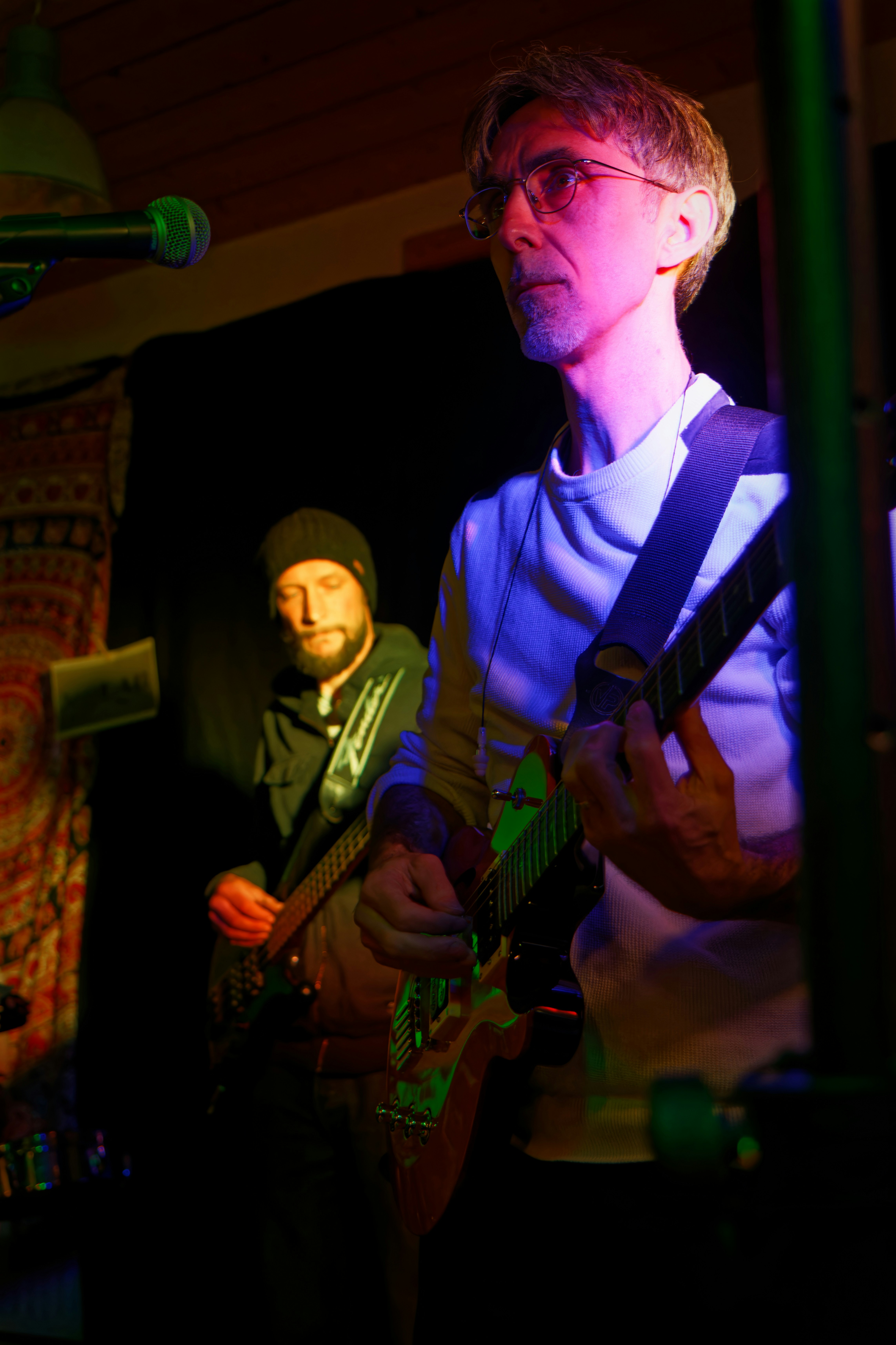 Guitarist in Neon Glow: Focus on the Front Man