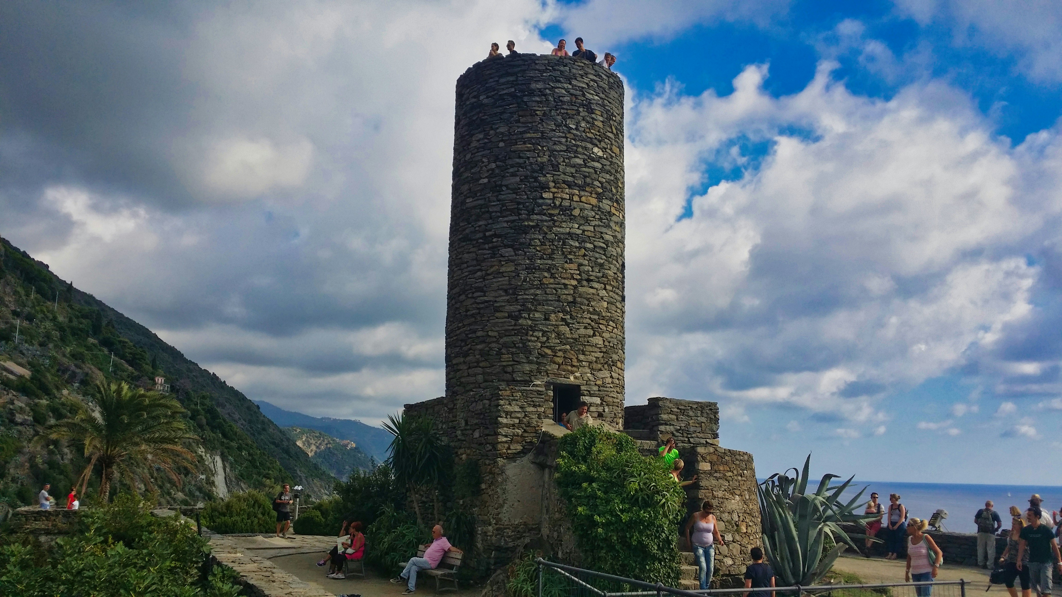 Stone tower overlooking the sea with people