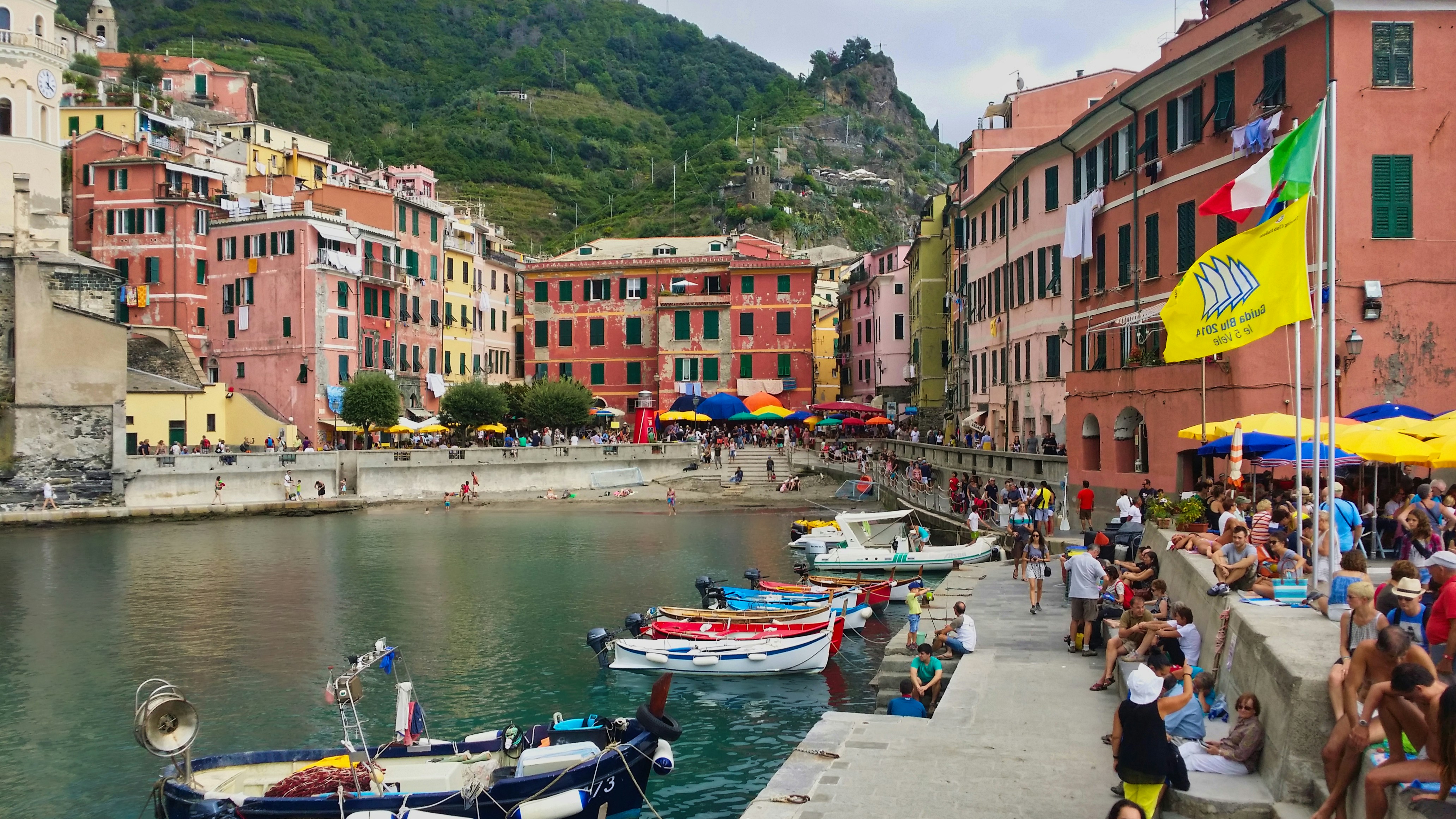 Colorful buildings line a canal with boats and people.