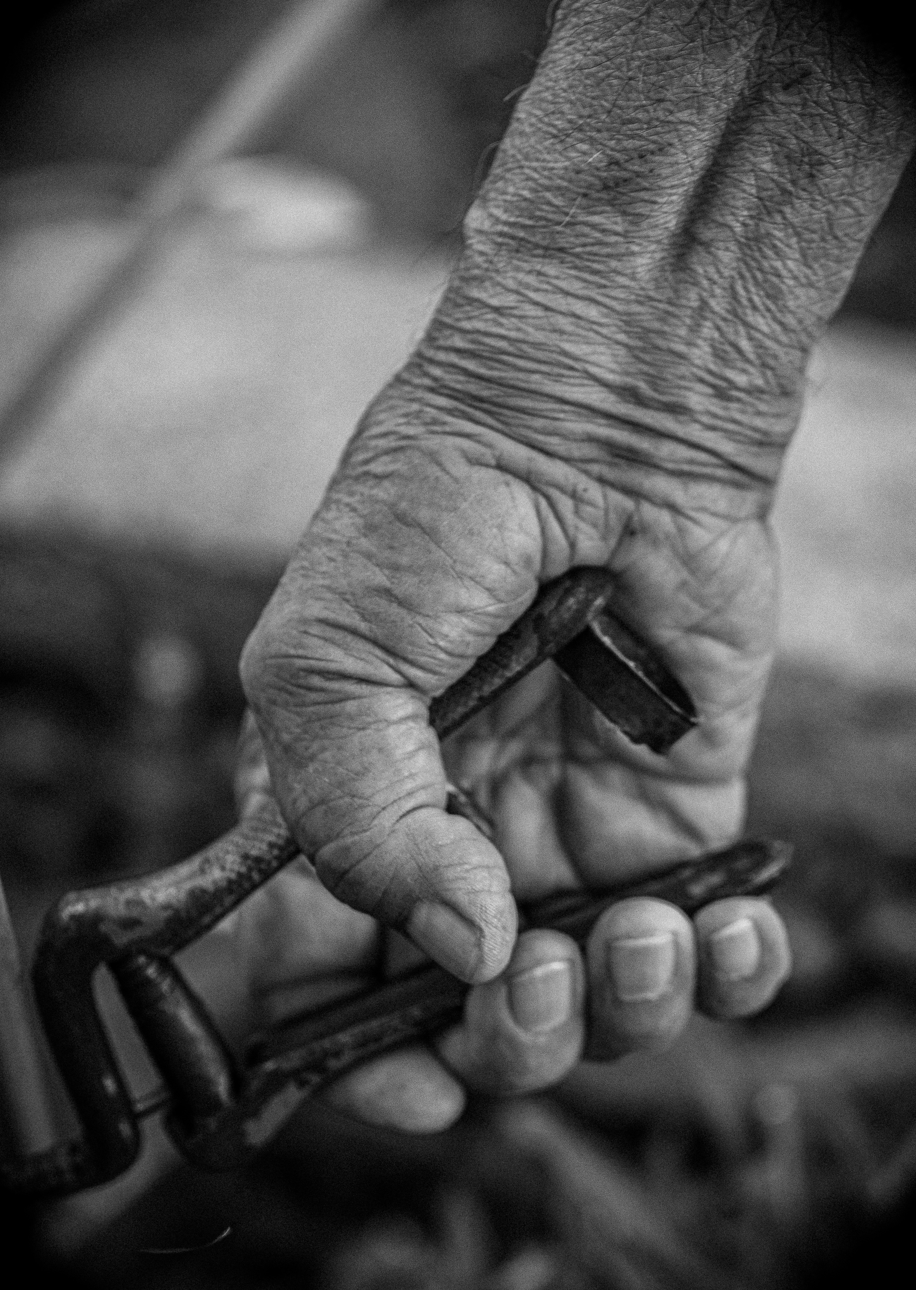 Elderly hand holding old rusty tools