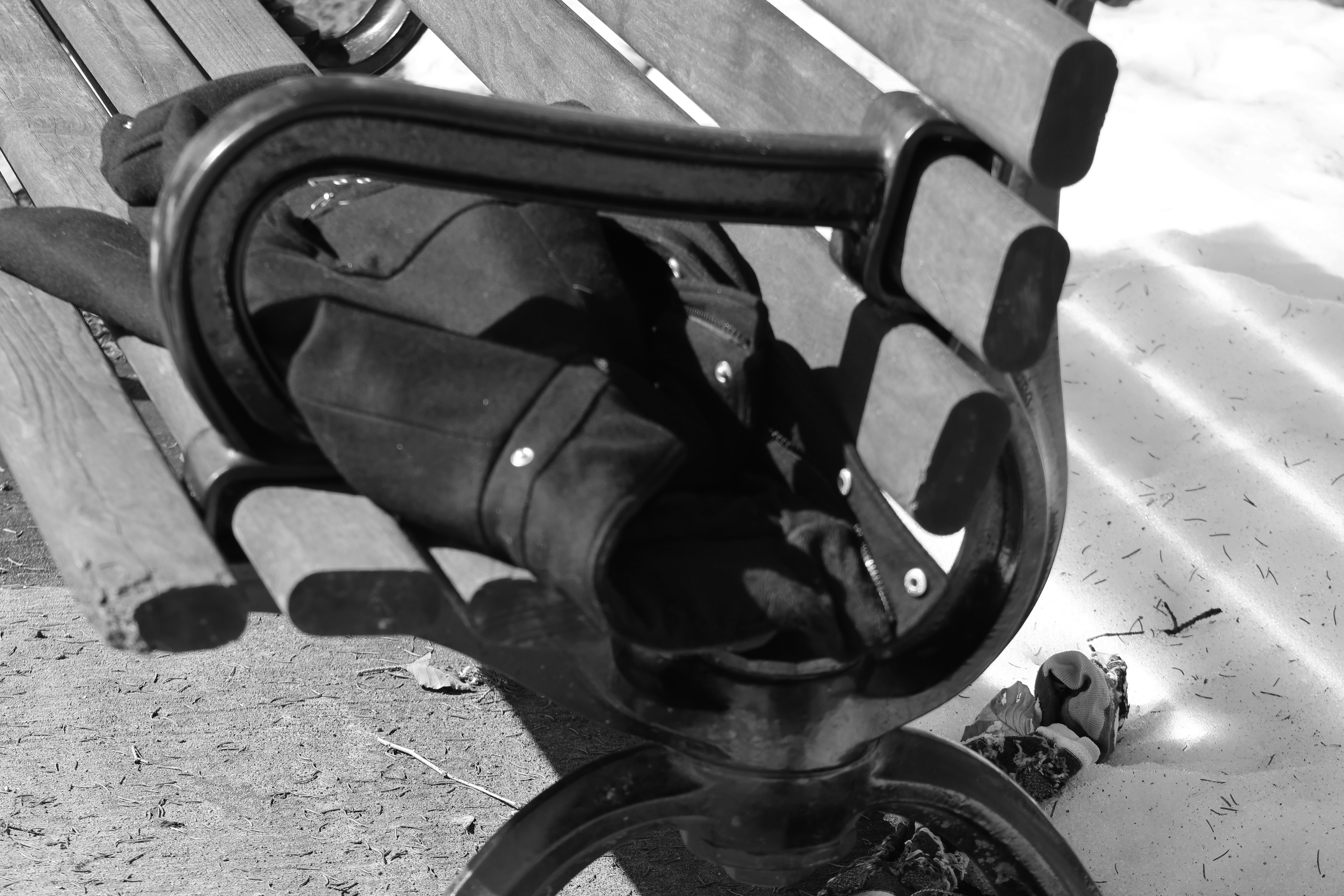 A pair of black boots on a park bench