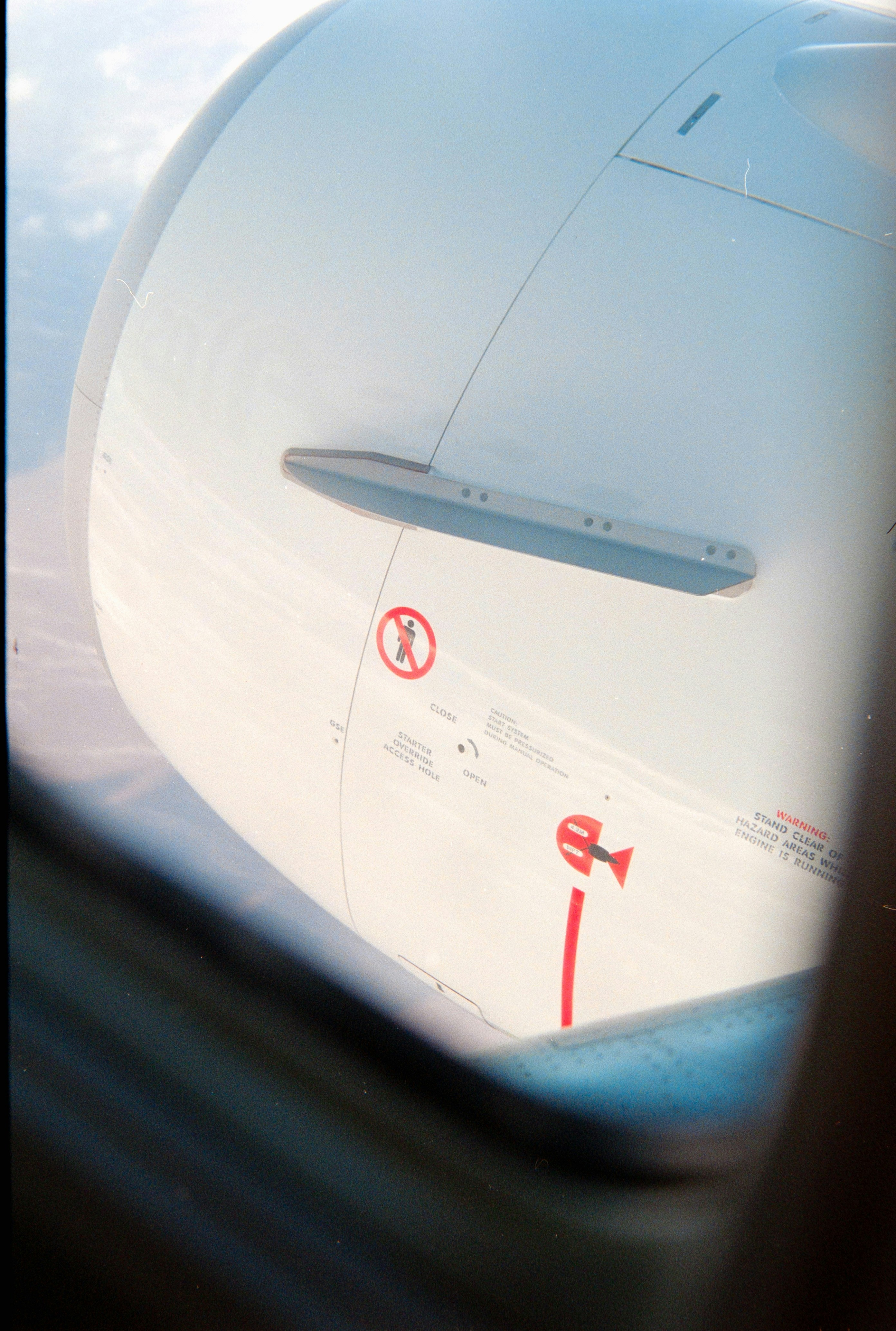 White jet engine curve with red safety icons in window frame