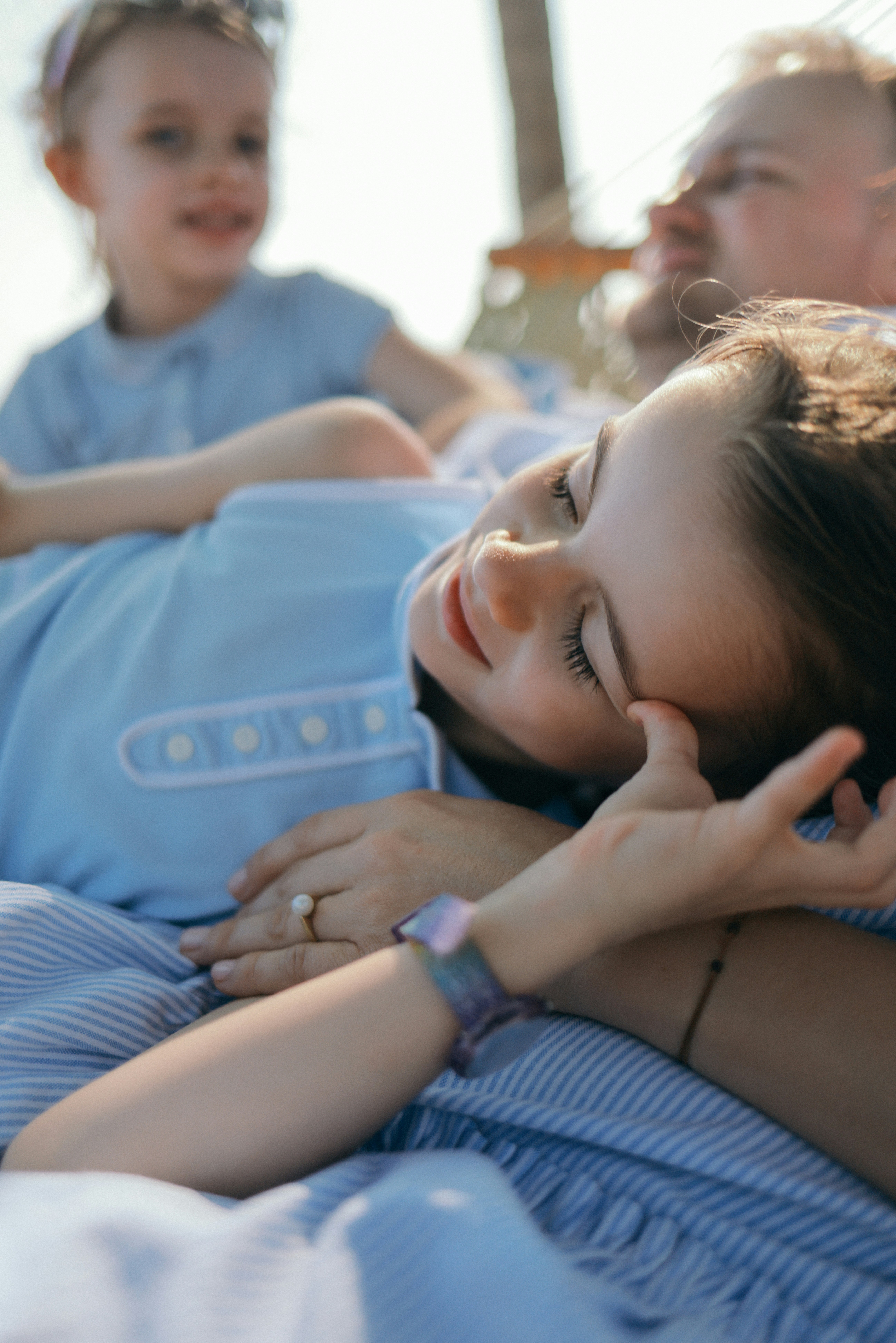 Close-knit Moment: A daughter rests on a parent's arm during a sunlit family scene