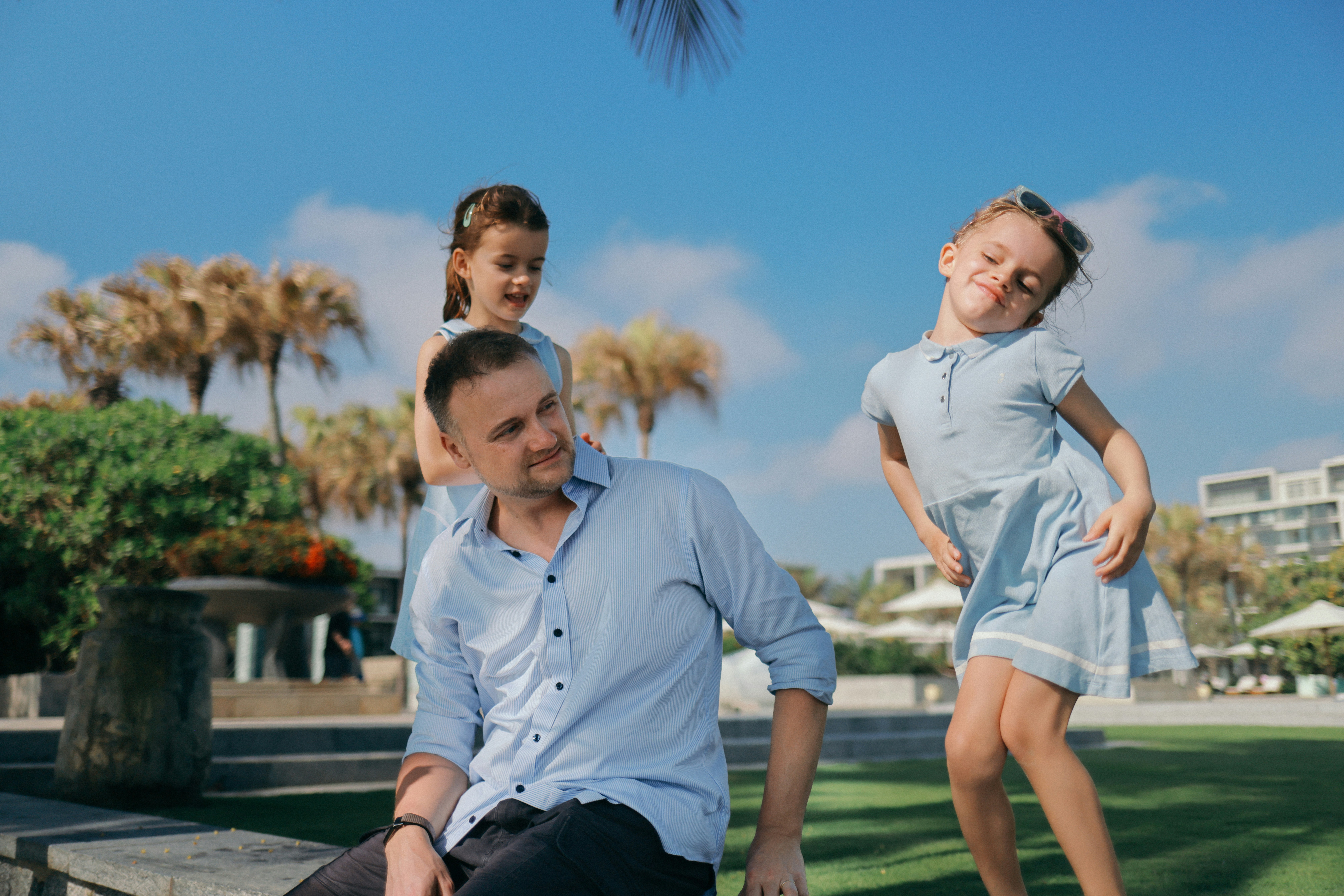 Dad’s Playground: A Moment of Laughter Beneath the Palm Shade