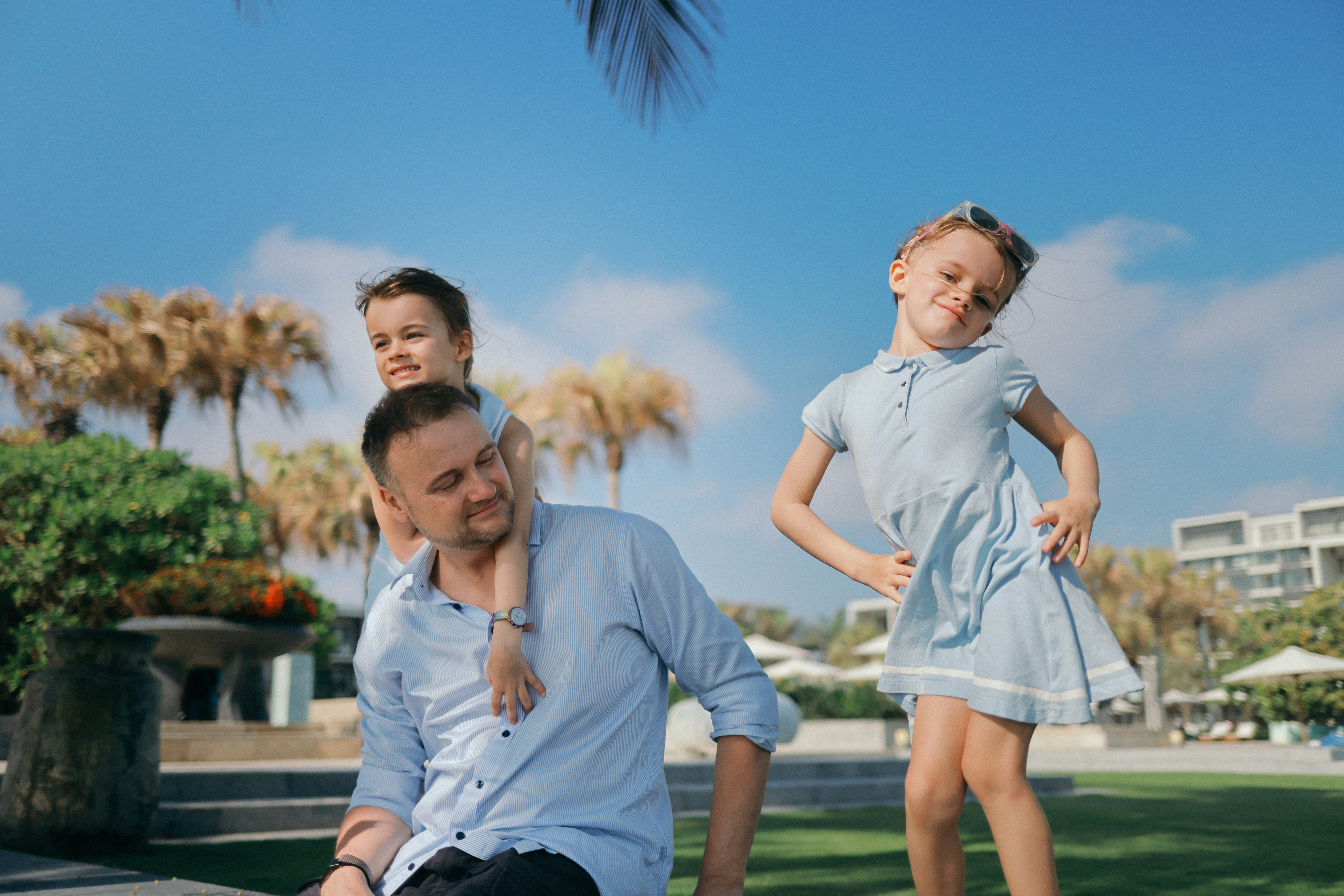 Sunlit family laughter by the resort lawn