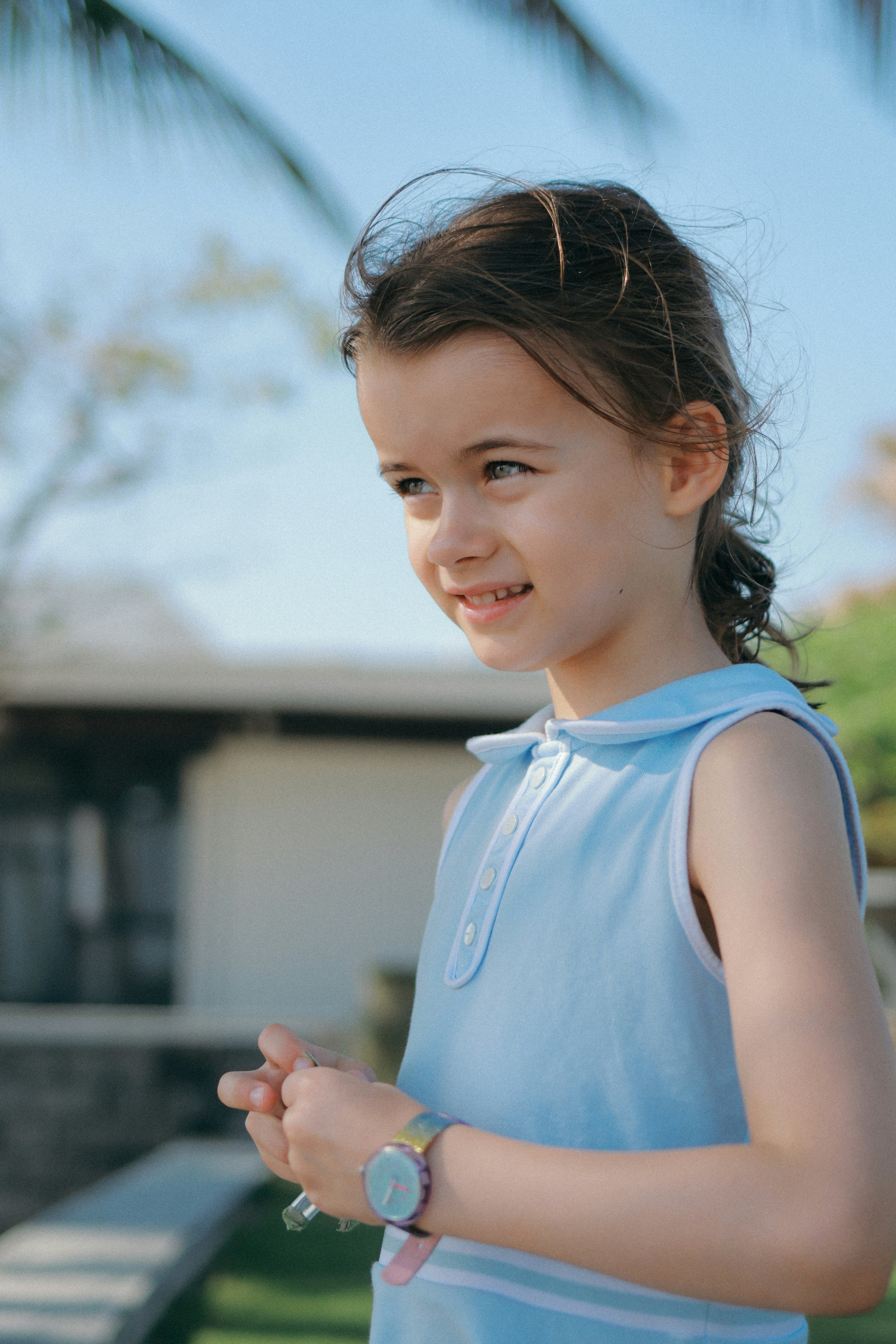 Young girl in blue dress with a watch