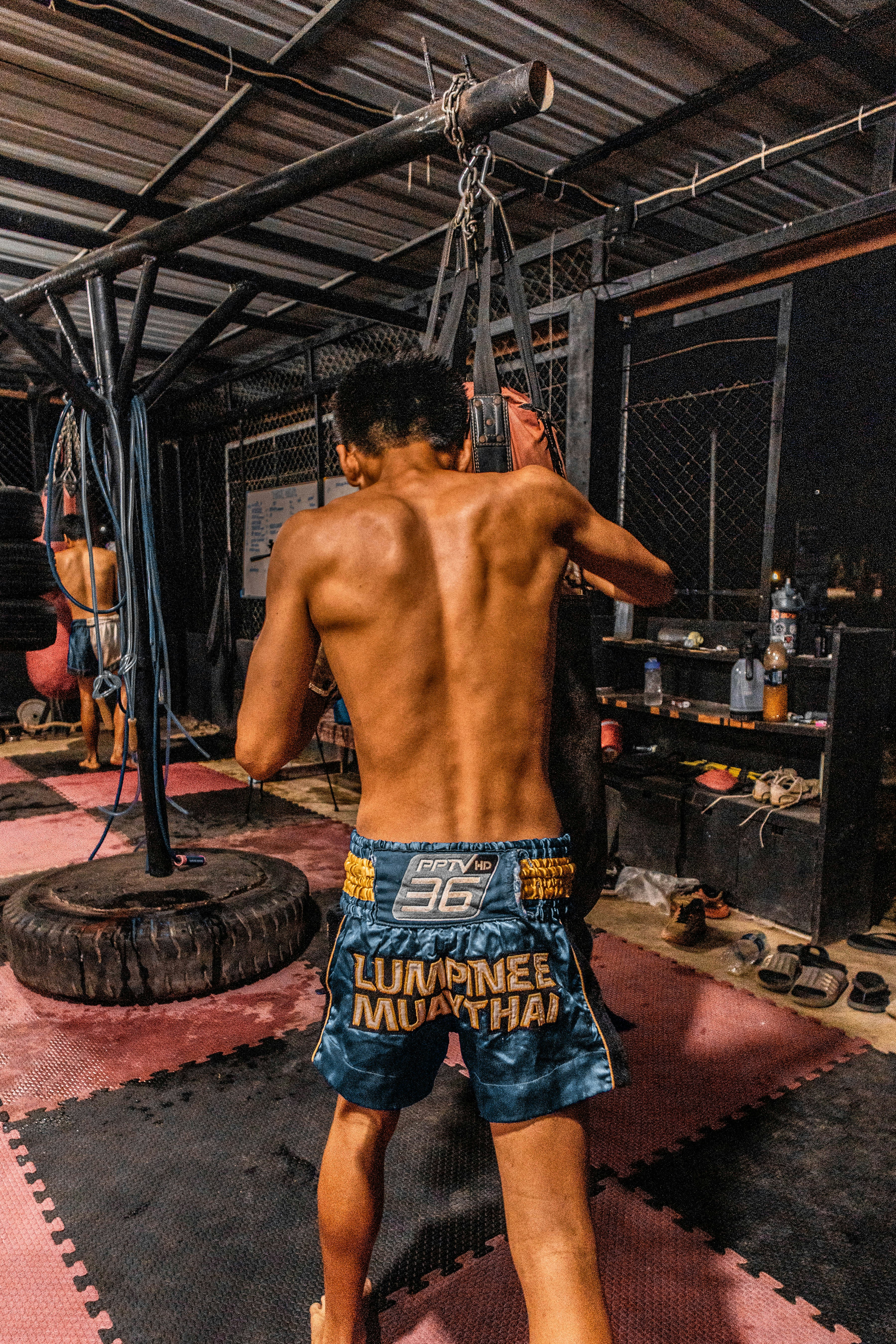 Backlit in the Ring: Focused Power Amid Hanging Bags