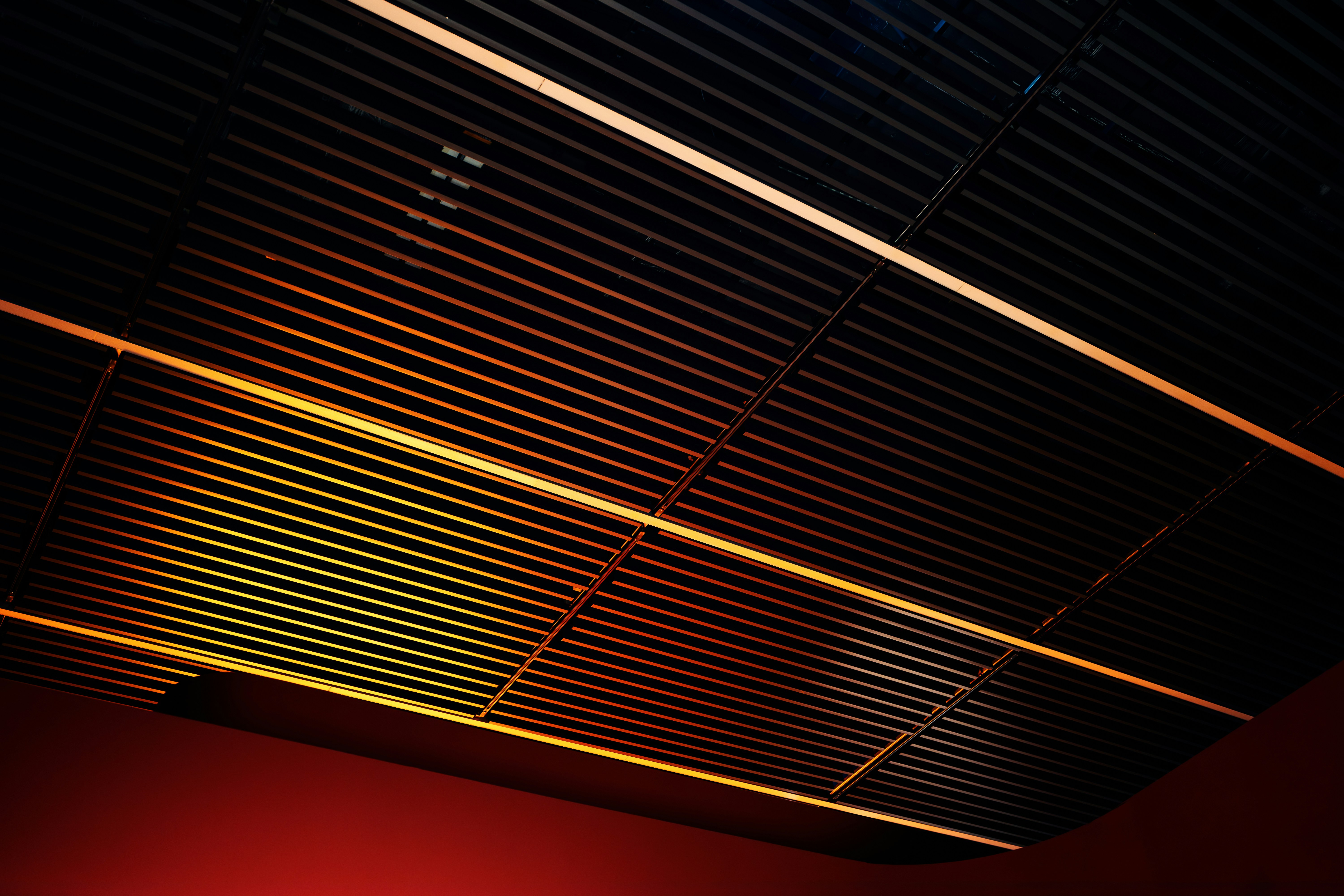 Warm Gridlines: Neon-Tinted Ceiling in Quiet Interior