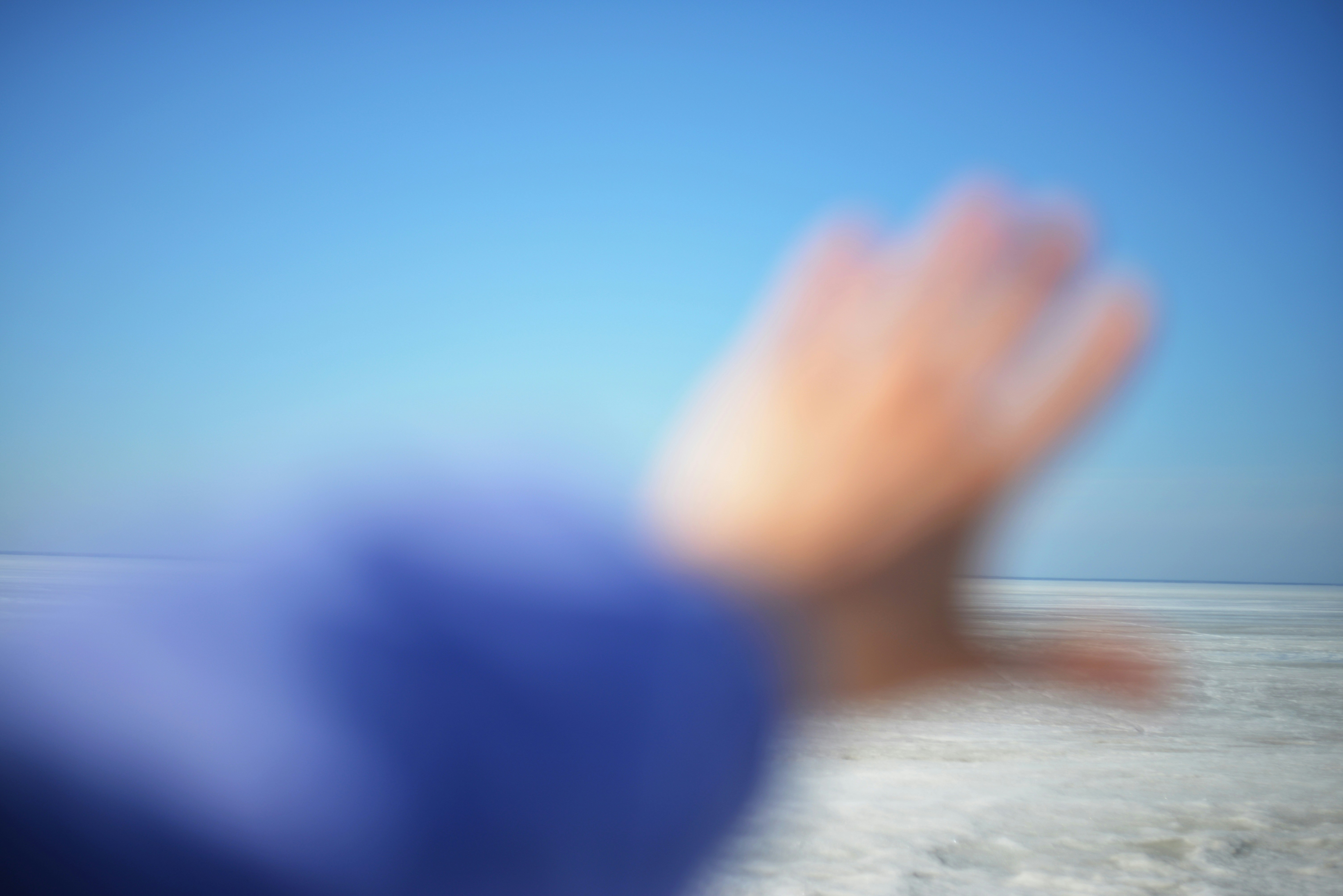 Blurred Reach at the Salt Flats: A Hand Halting the Horizon