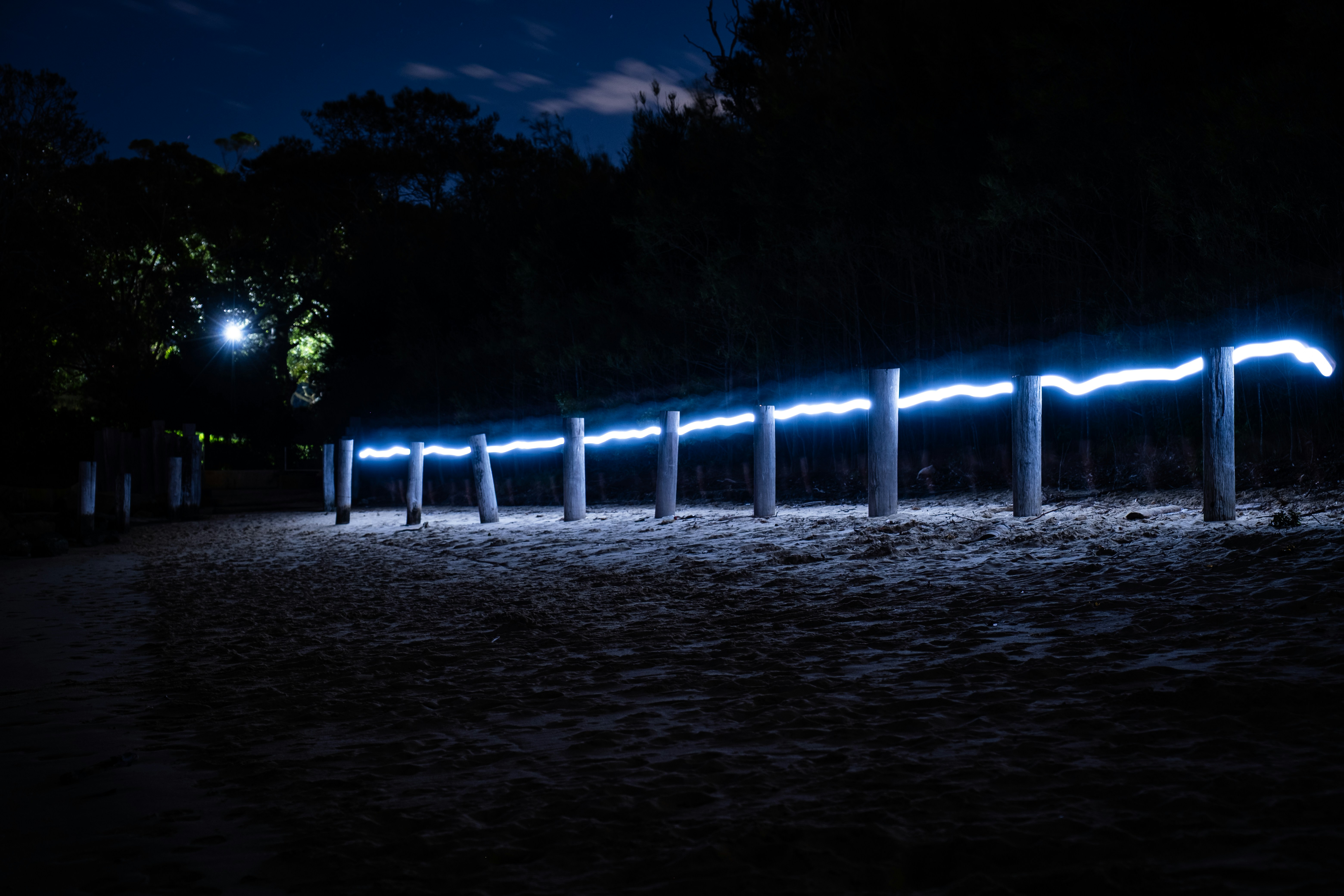 Glowing Rope Light Traces Across a Moonlit Beach Path