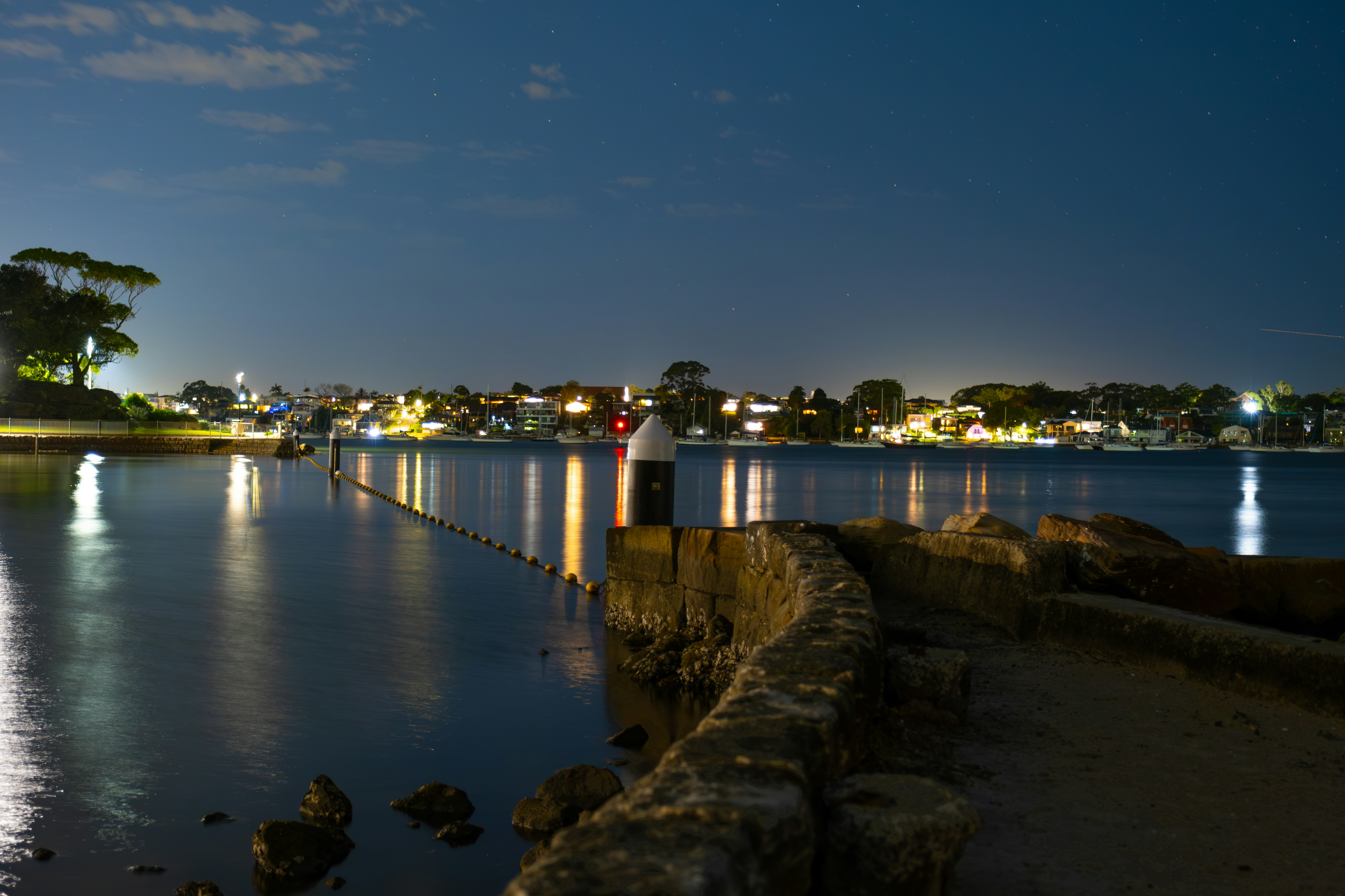 Moonlit Harbor: Reflections Along the Stone Pier