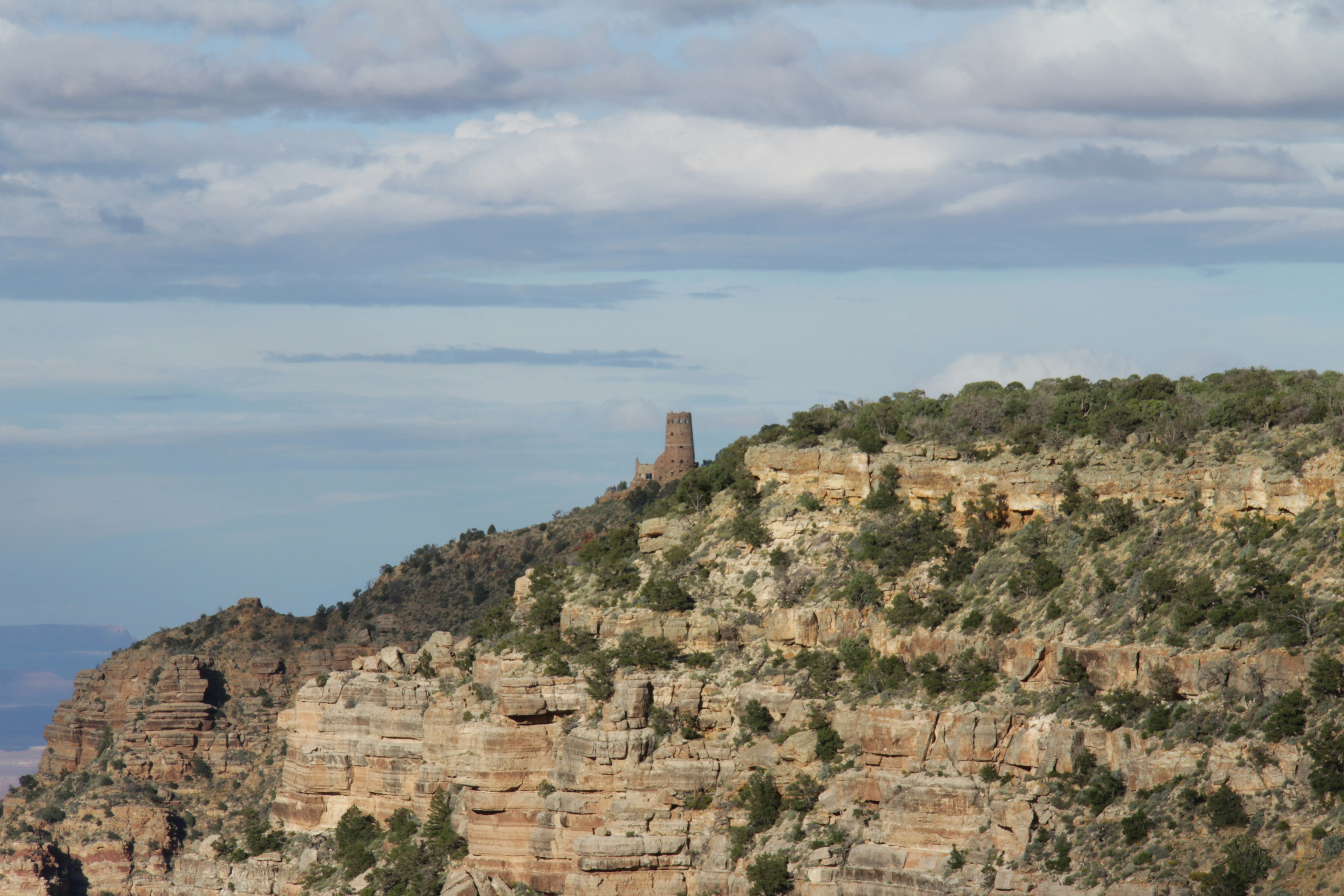 A lone turret atop the cliff—standing watch over layered sandstone