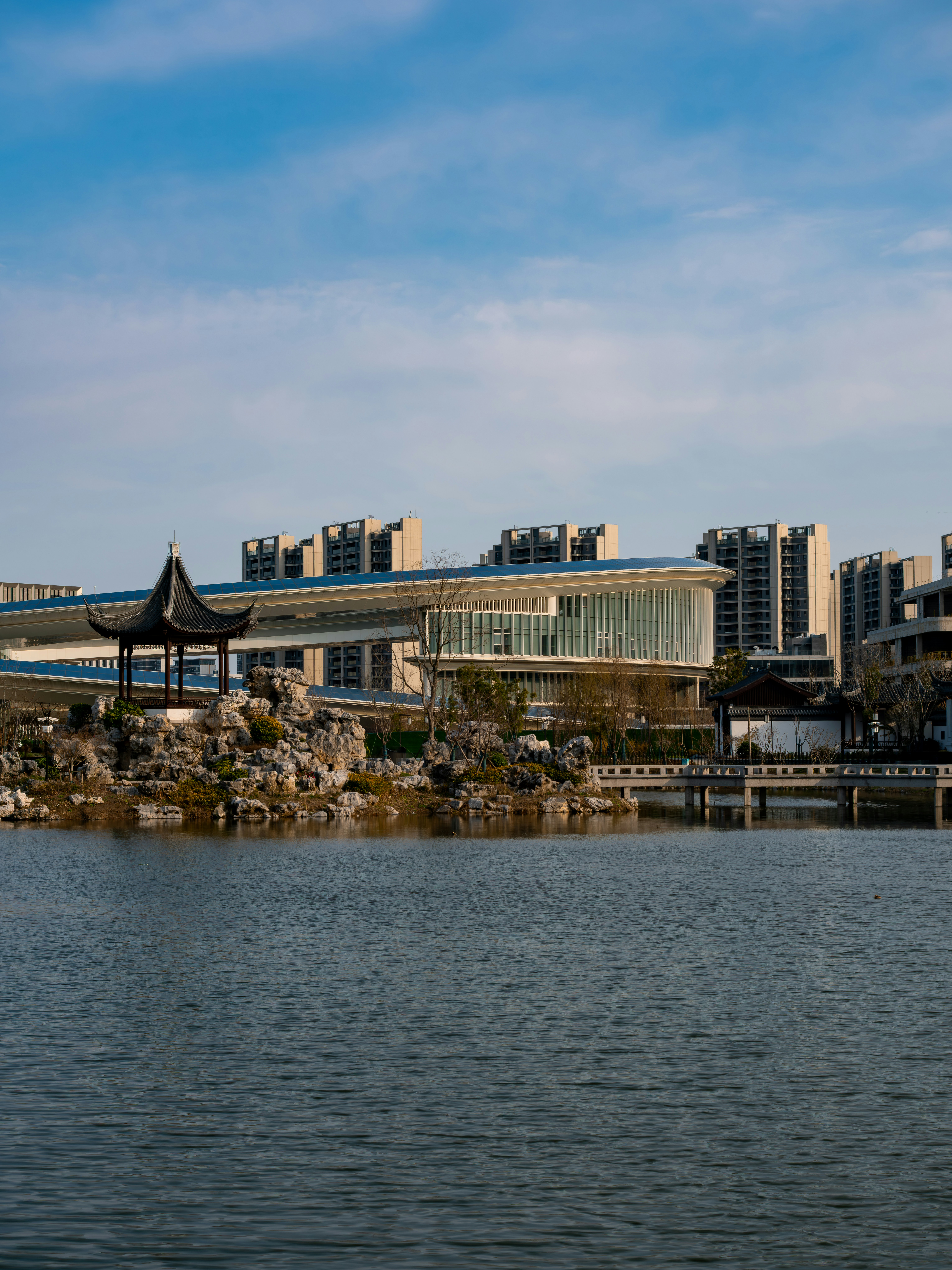 Waterfront Pavilion: Modern Glass and Rock Across the Quiet Lake