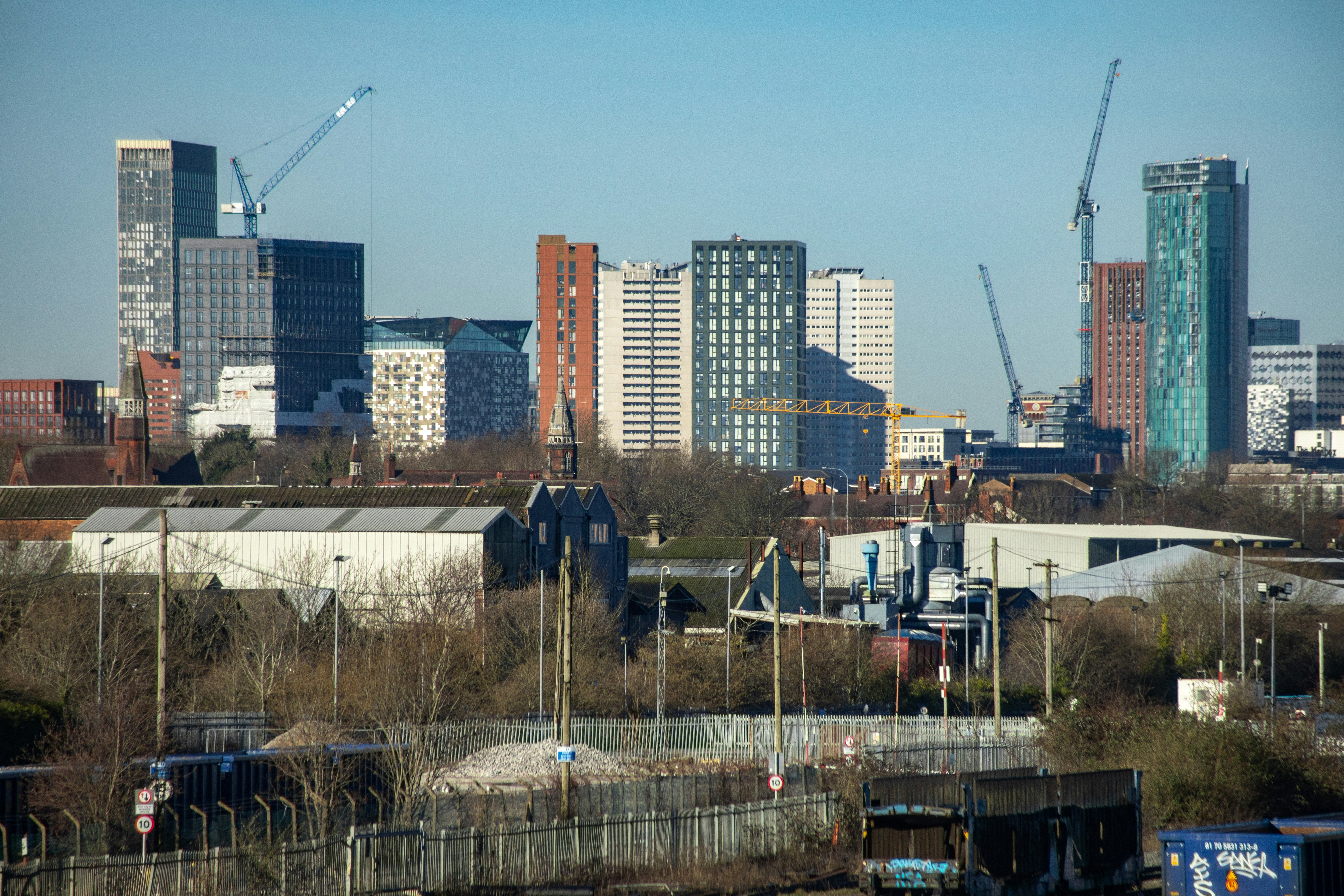 Cranes at Dusk Over a Modern Riverside District