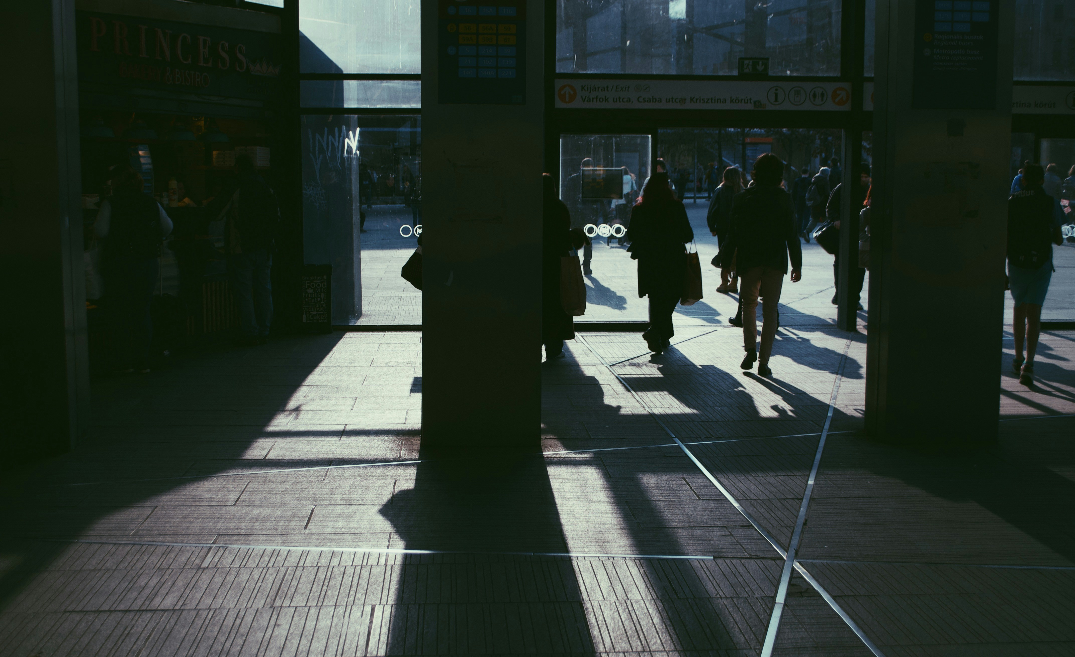 Silhouettes in the Terminal: Sunlit Stride Through Pillars