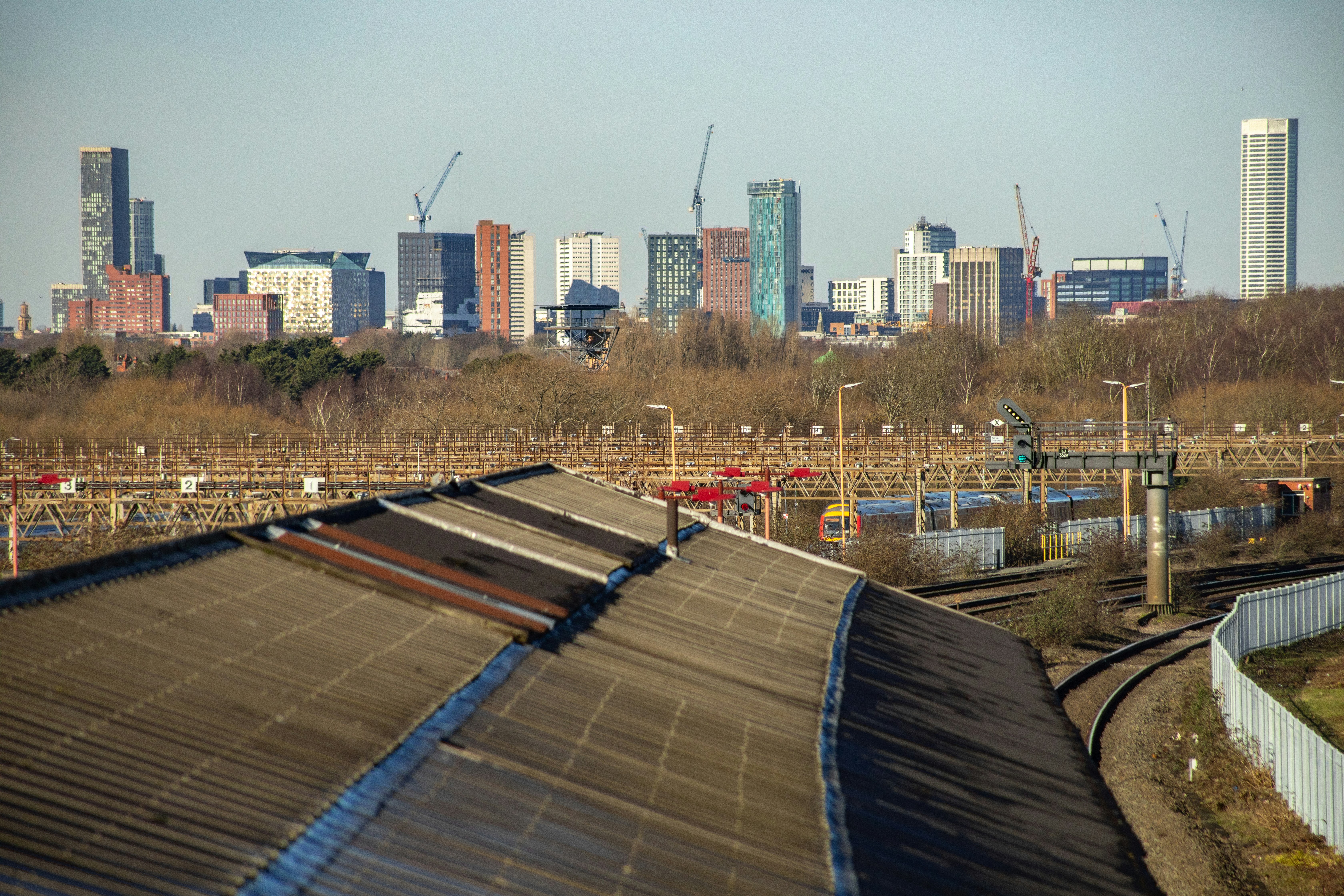 City Skyline Emerges Behind an Arc of Industrial Tracks