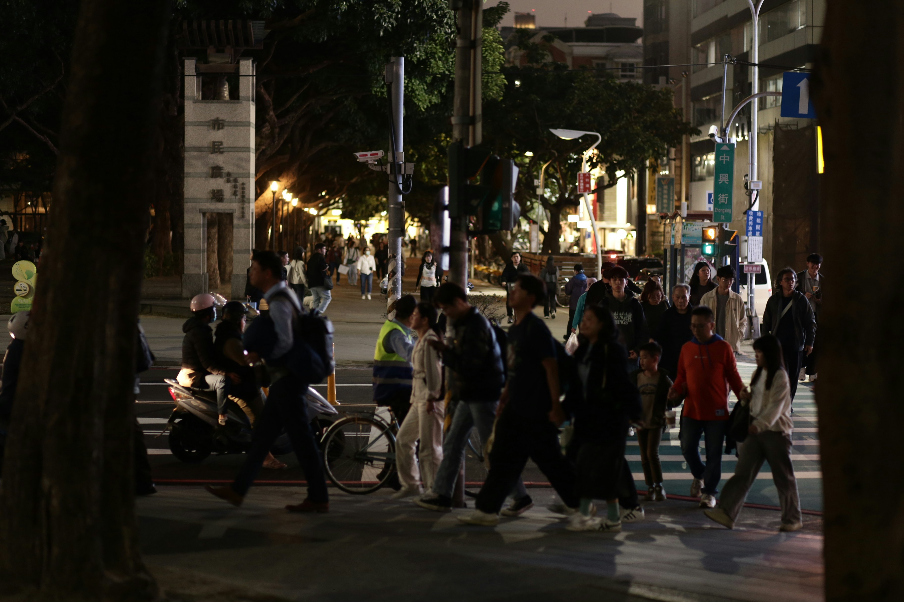 Night Crossing: A Crowd’s Quiet Rhythm Under Streetlight Glow