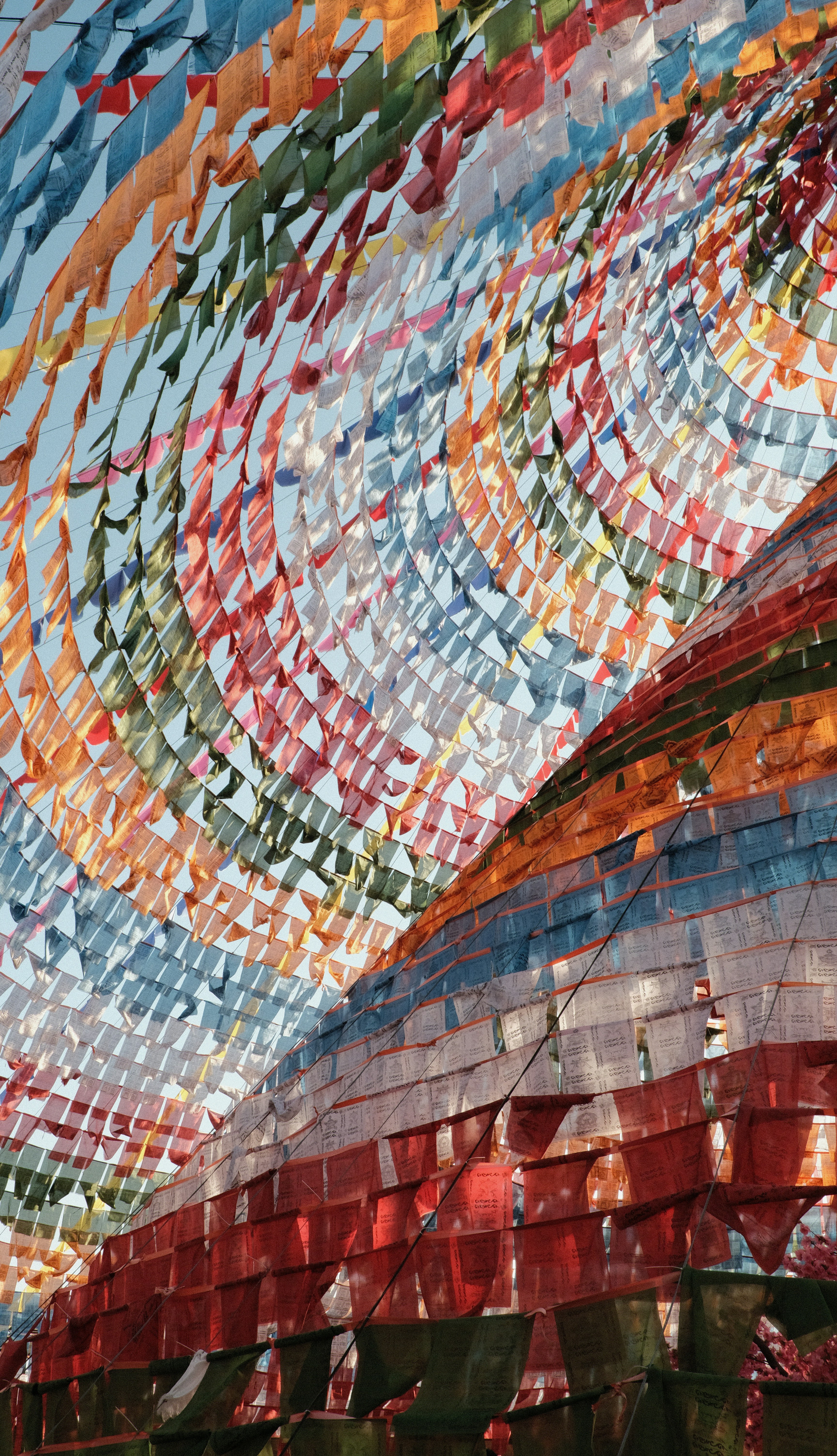 Colorful prayer flags strung across a clear sky