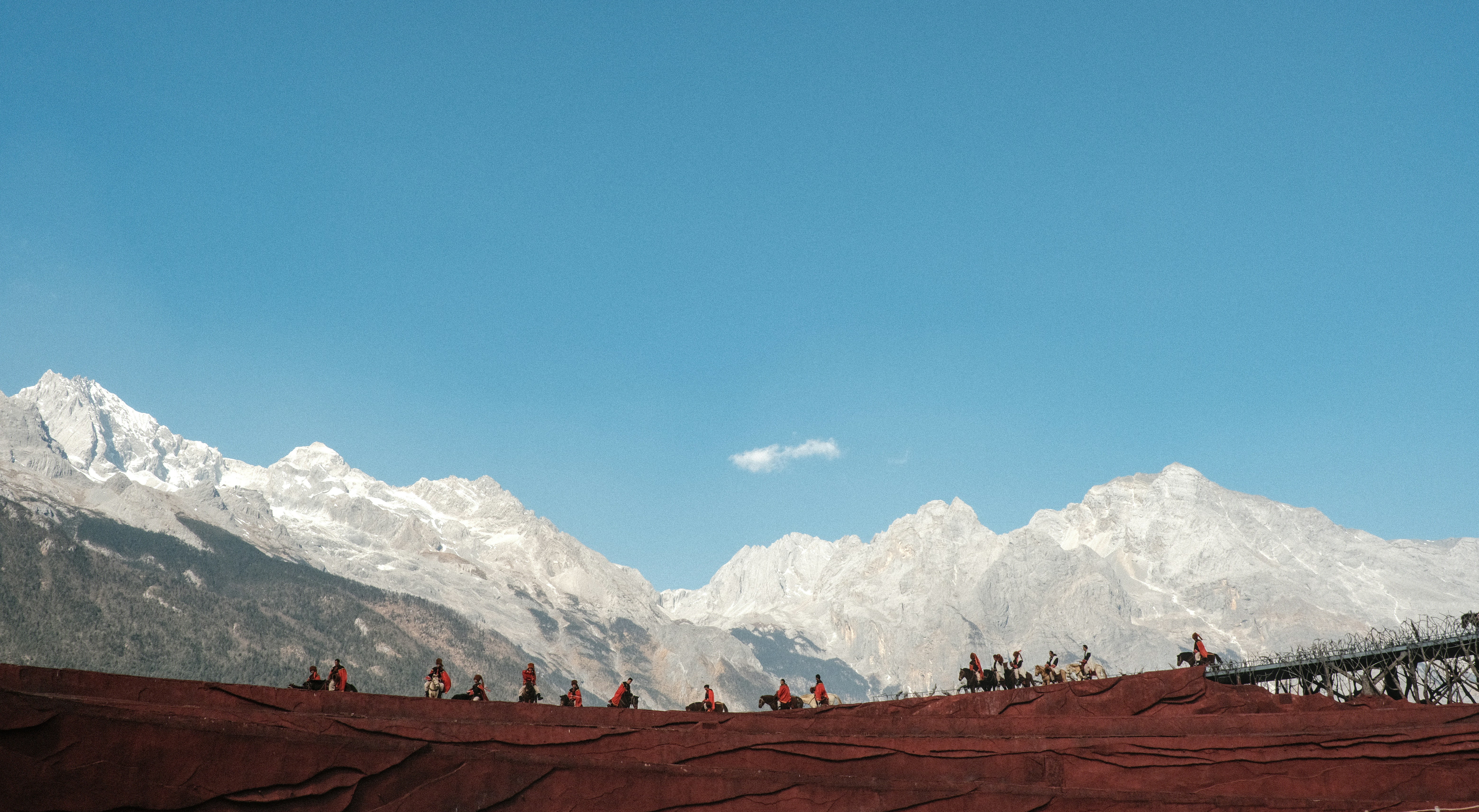 Line of Runners Beneath Snow-crowned Peaks