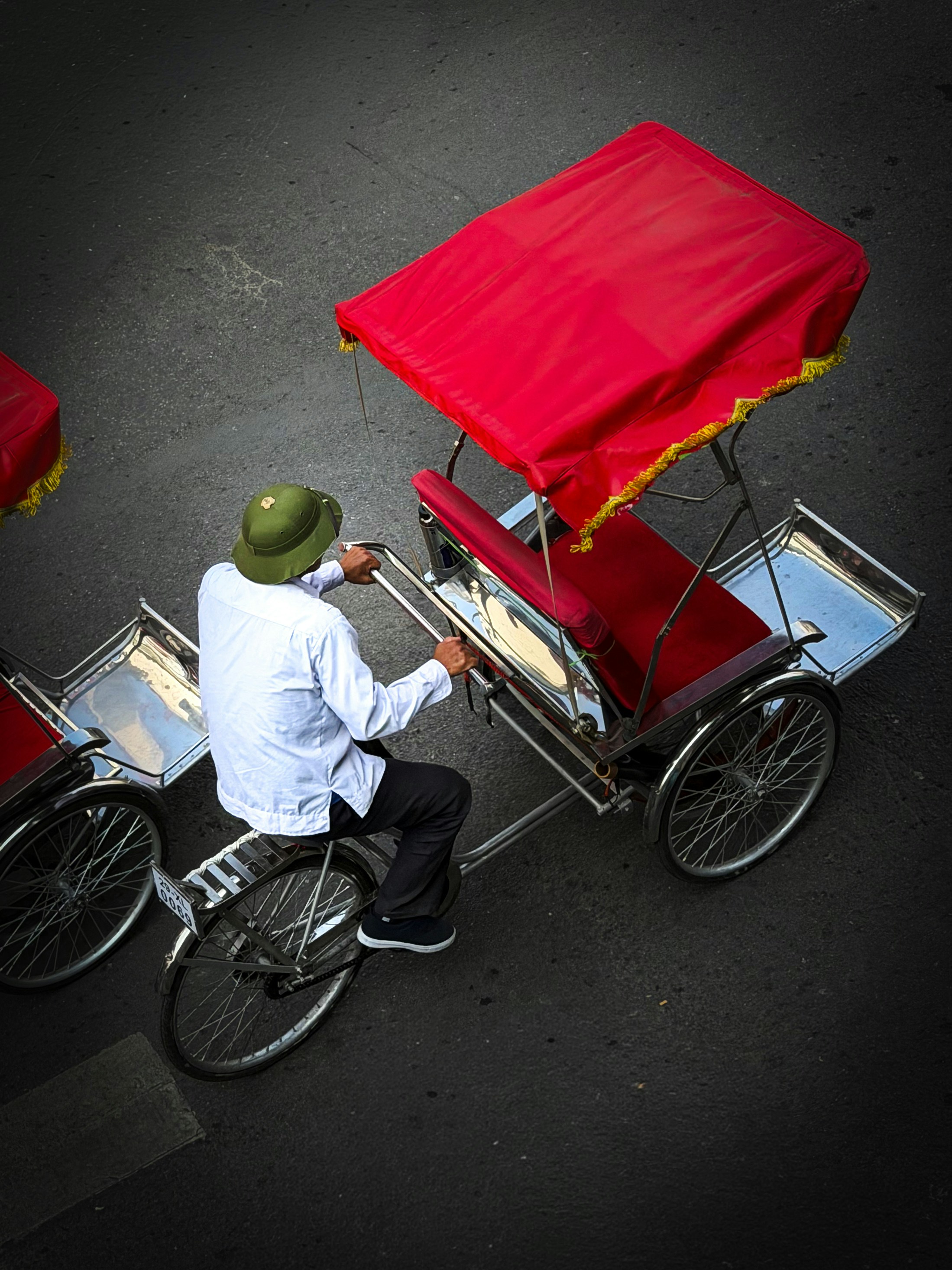 Red-roofed Pedicab in Motion: A Aerial Perspective of Daily Transit