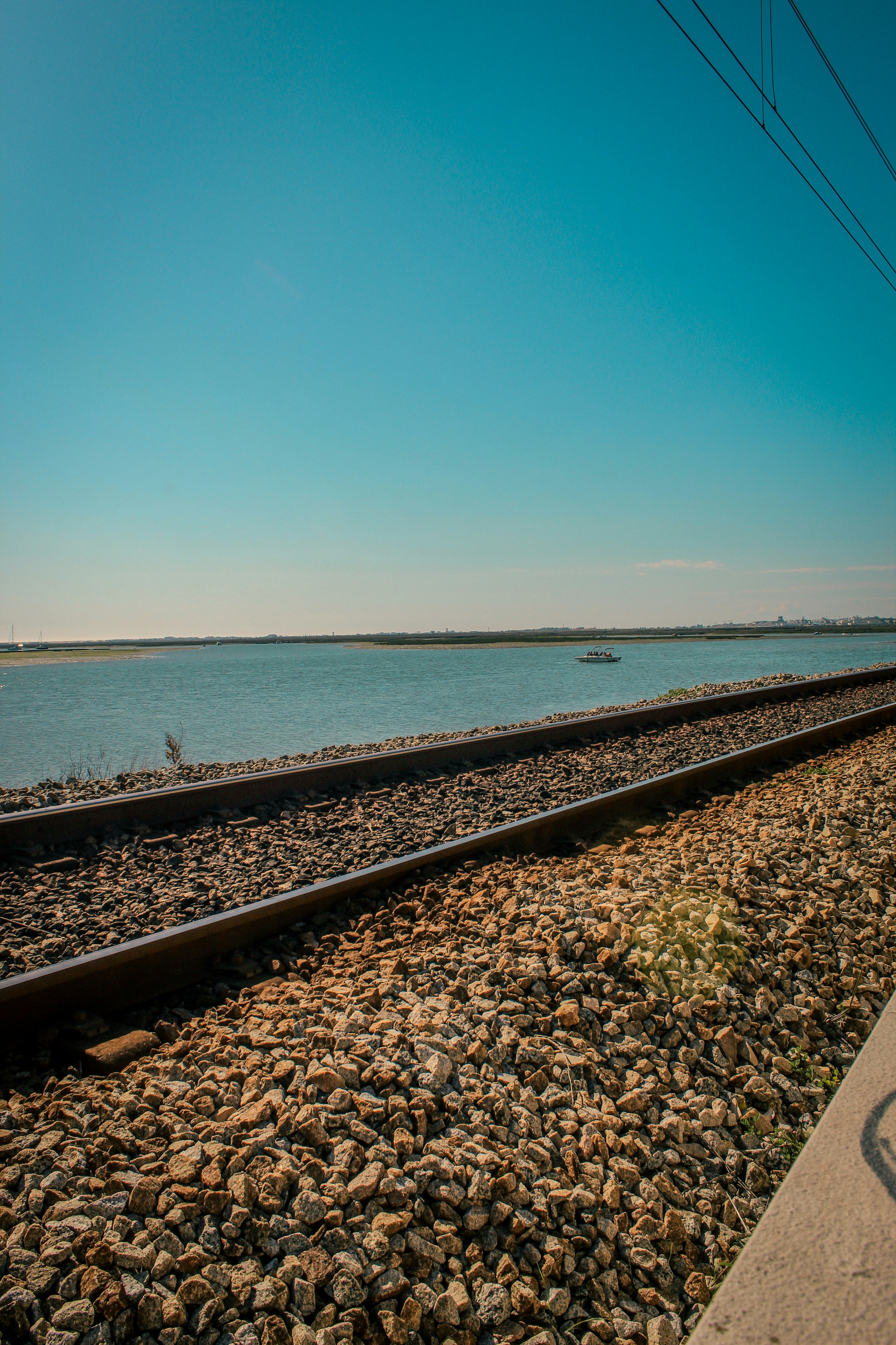 Railway Edge: Calm Water Meets Metal and Gravel