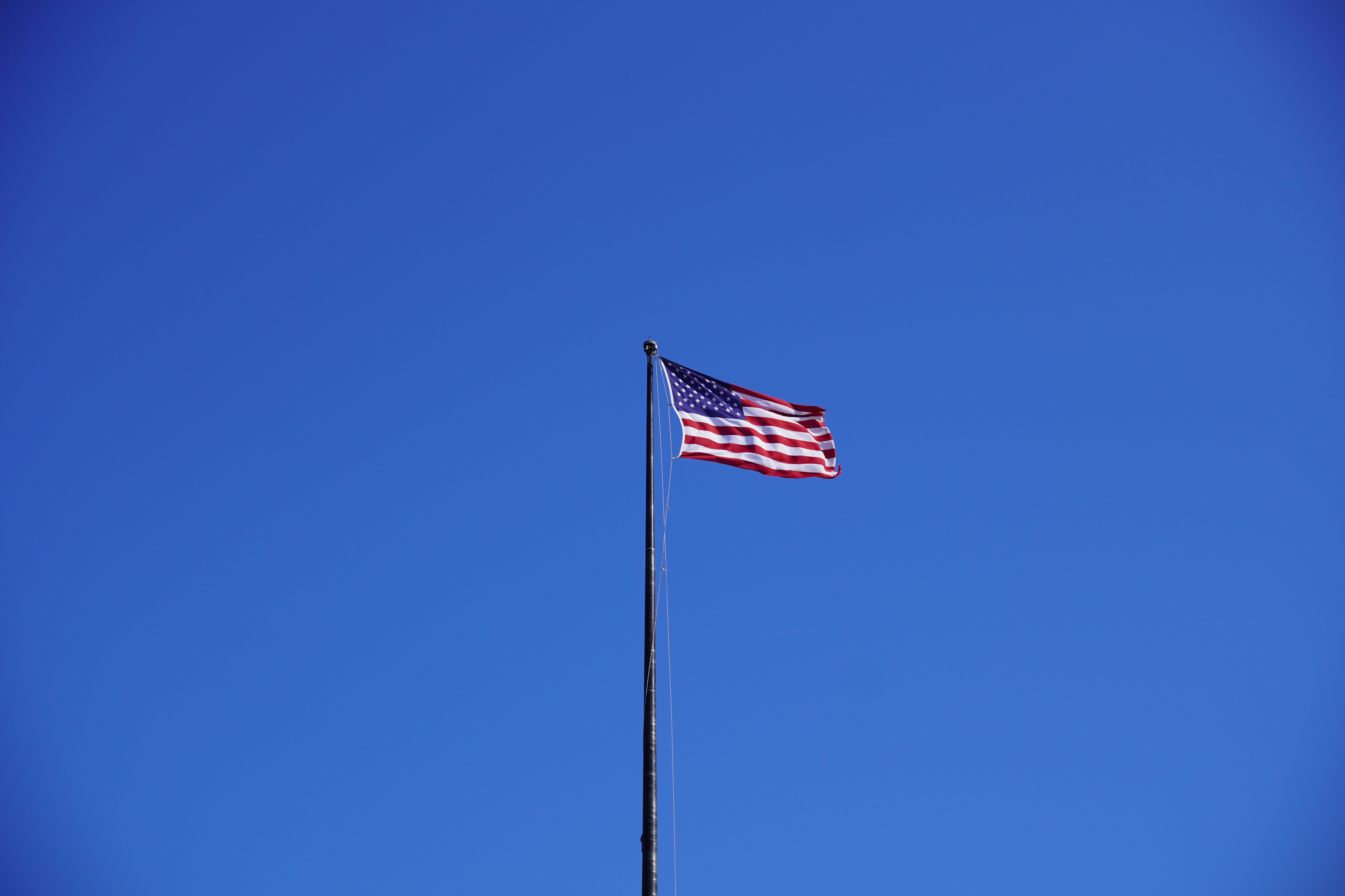 Flag on a Clear Horizon: A Lone Banner Against Blue