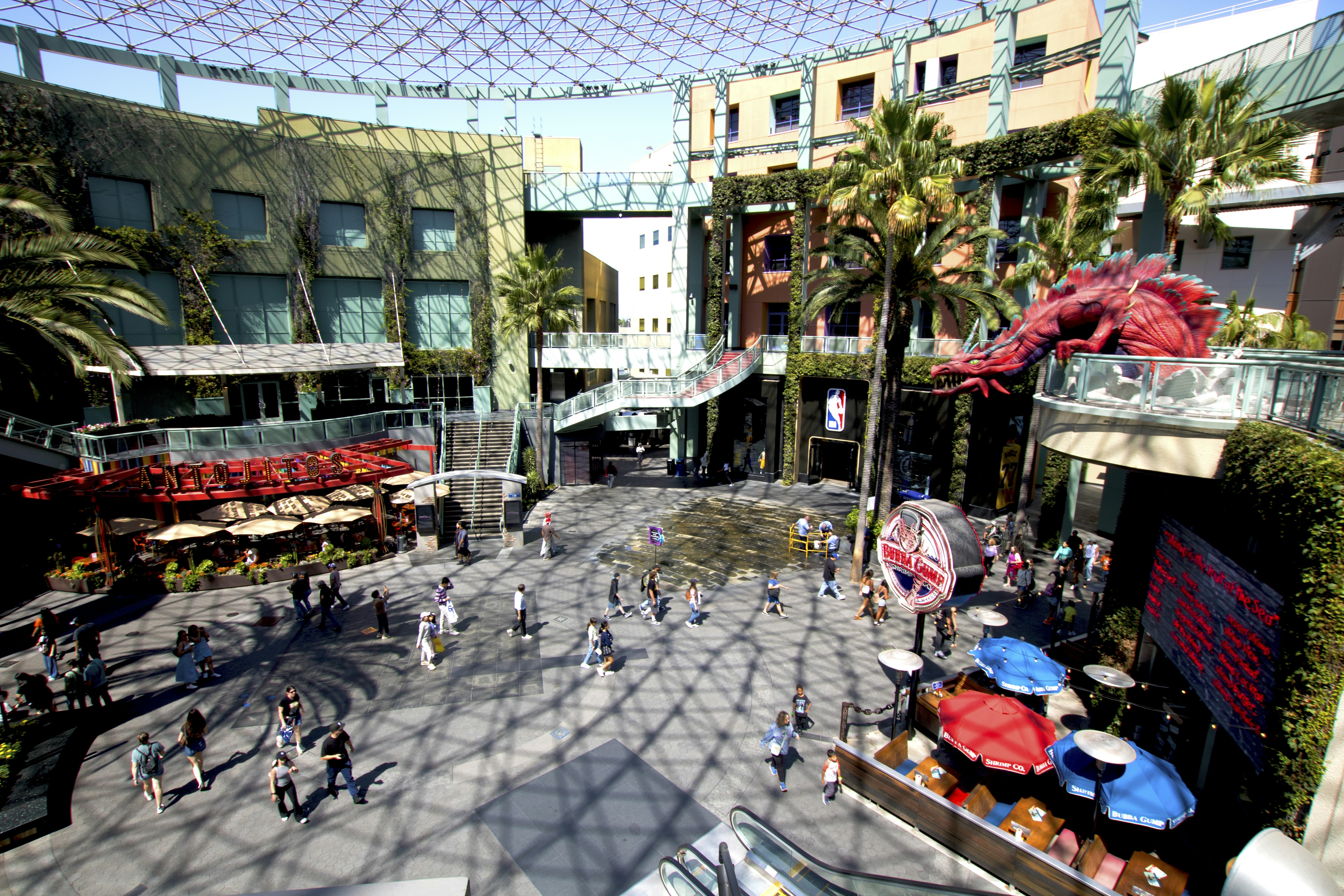 Open-air Atrium: People and Palm Shadows Beneath a Glass Canopy