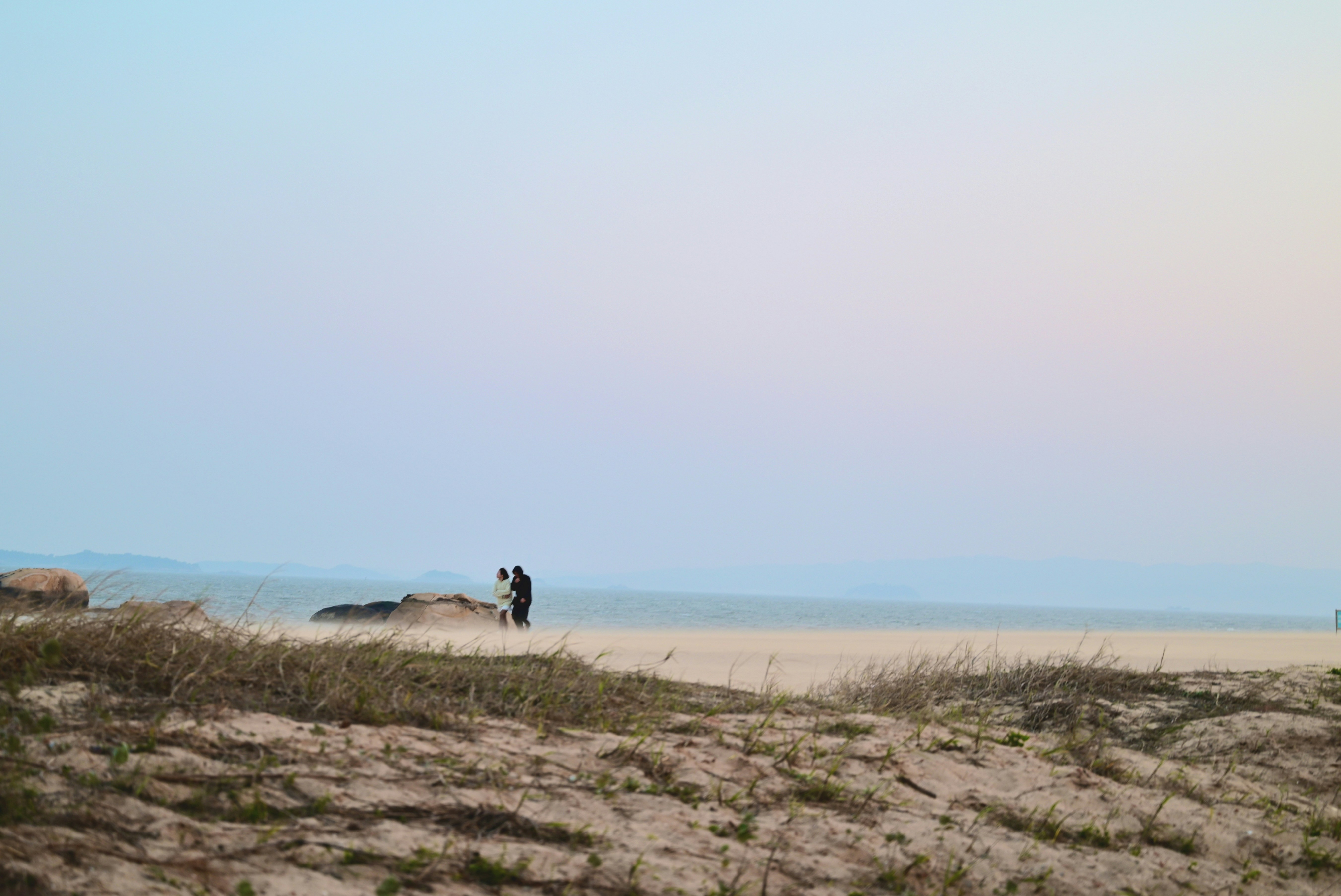 Two Silhouettes at Dusk: A Quiet Beach Moment