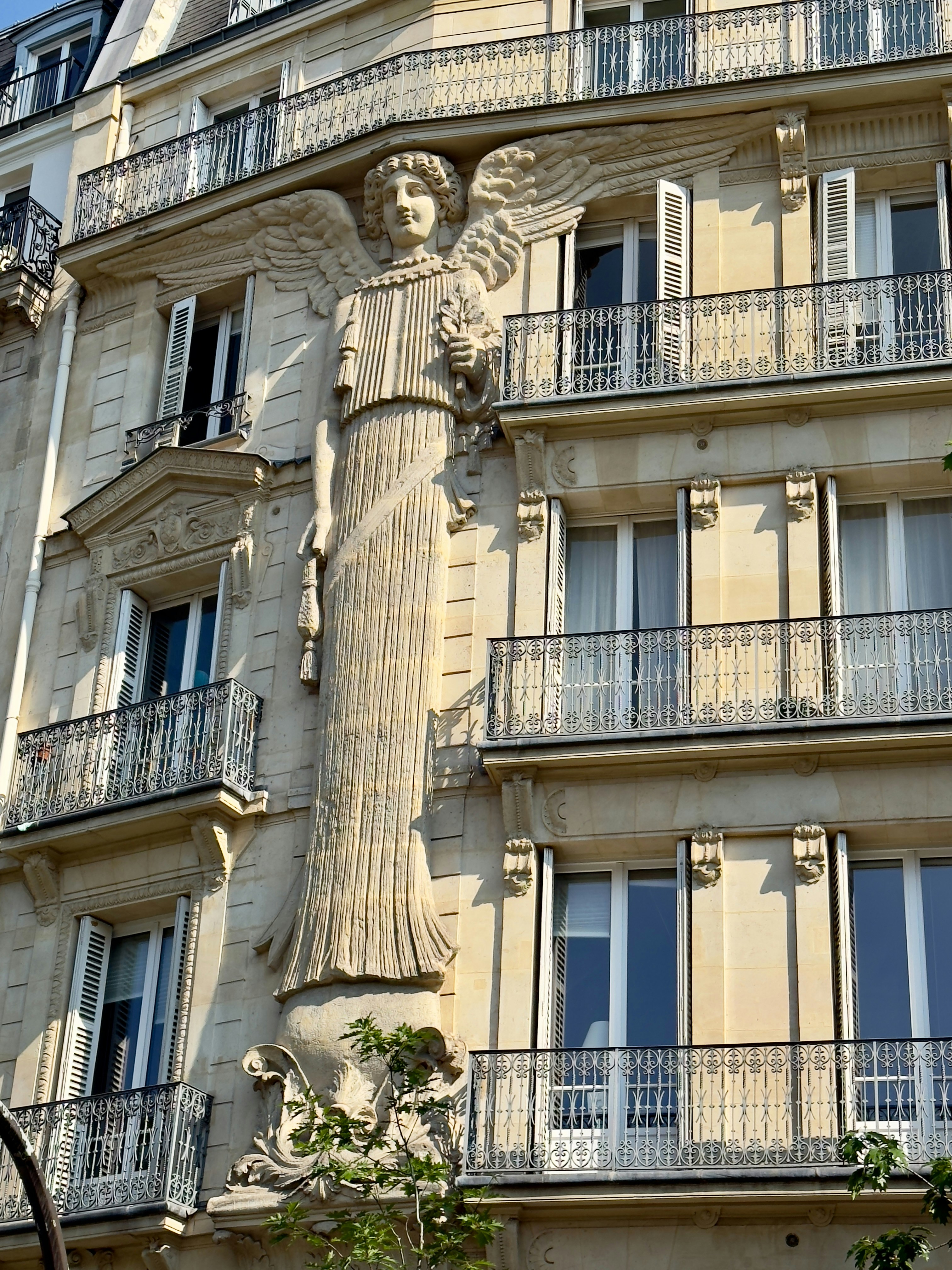Winged guardian overlooks Parisian facade
