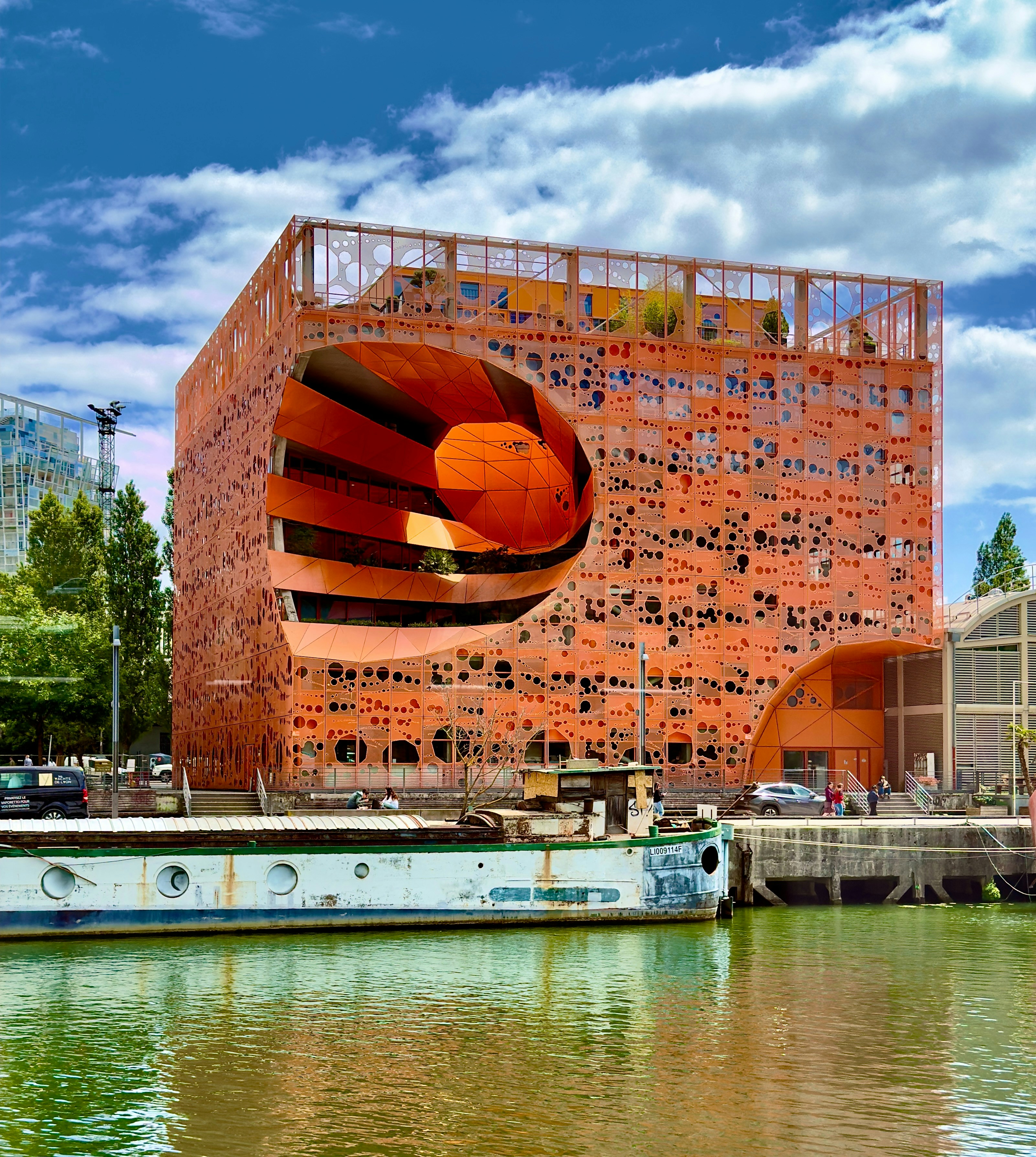 Copper Echo: A Spiraling Atrium Rising from the River