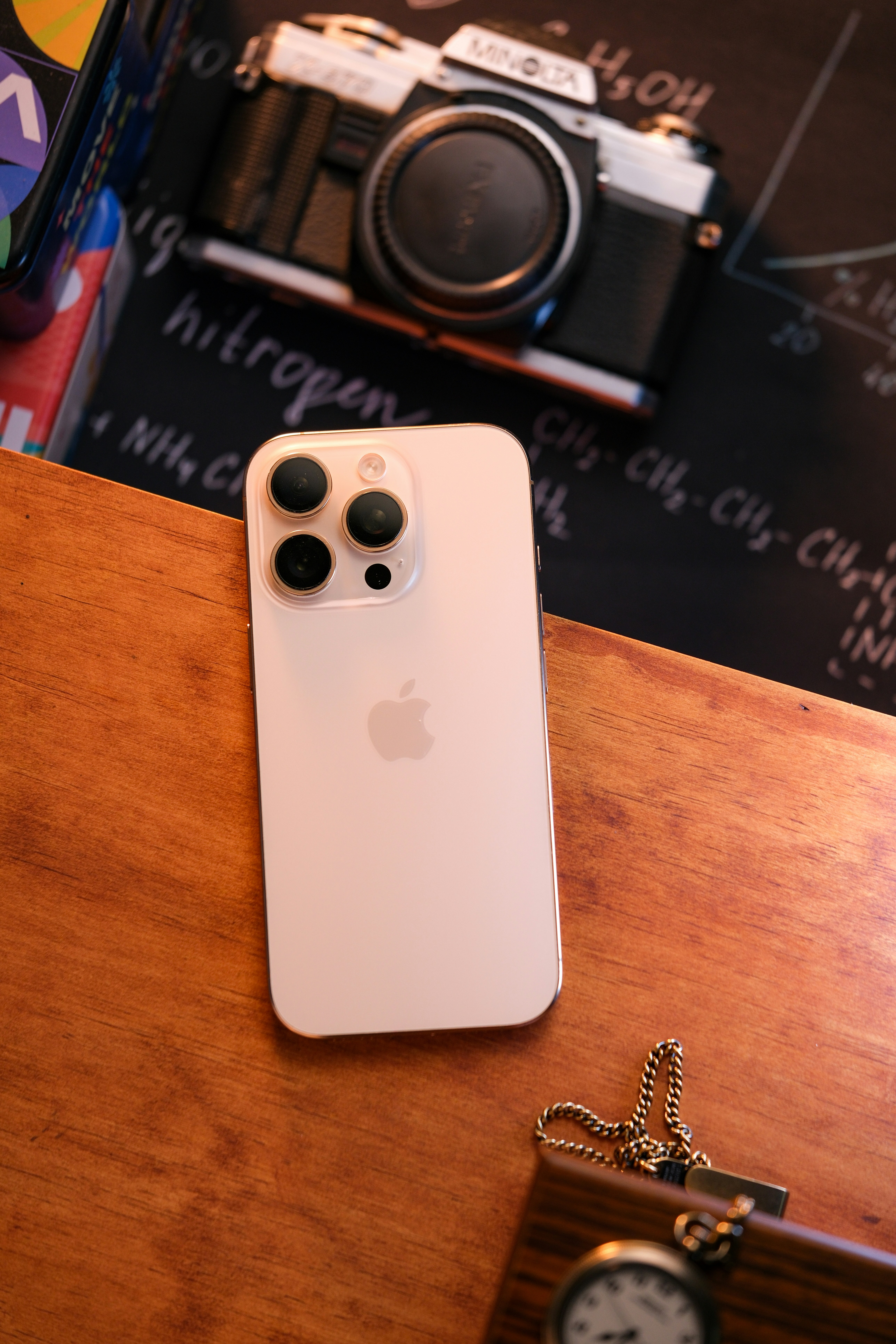 Metallic Calm: The iPhone Resting on a Warm-wood Table Amid Vintage Equipment