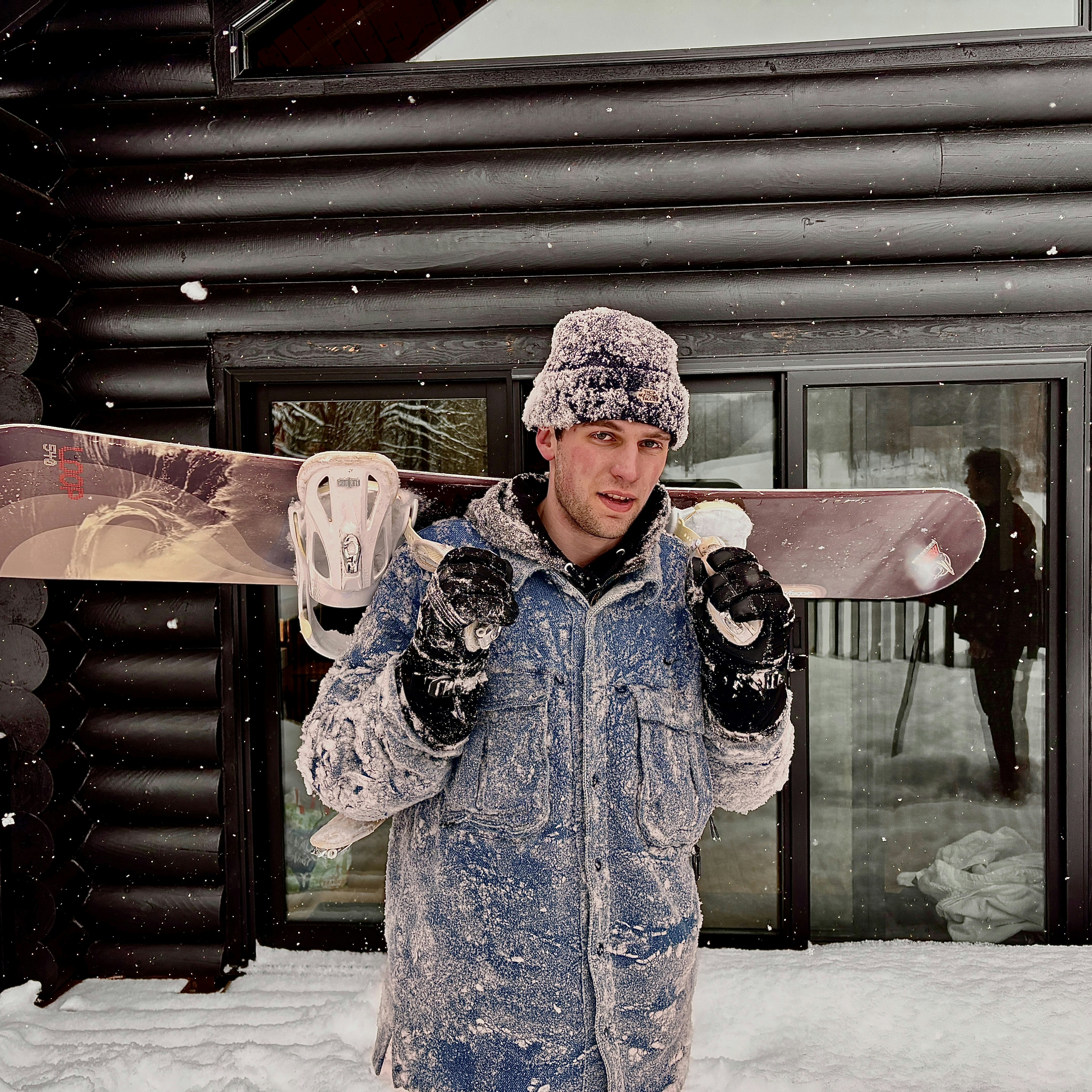 Snowbound Rider: snowboarder pausing at the cabin doorstep