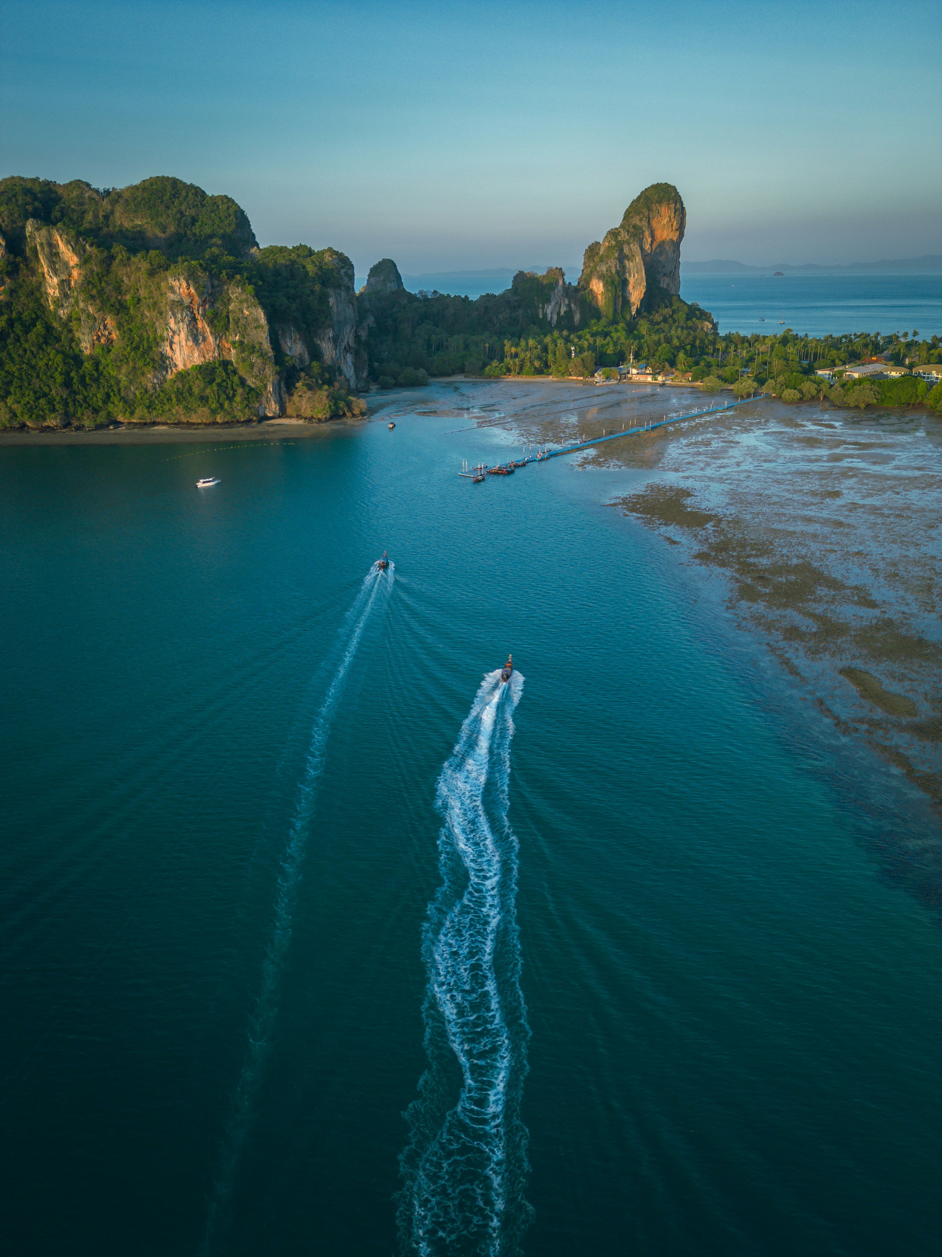 Azure Whispers: Boats Carving Trails past the Cliffs