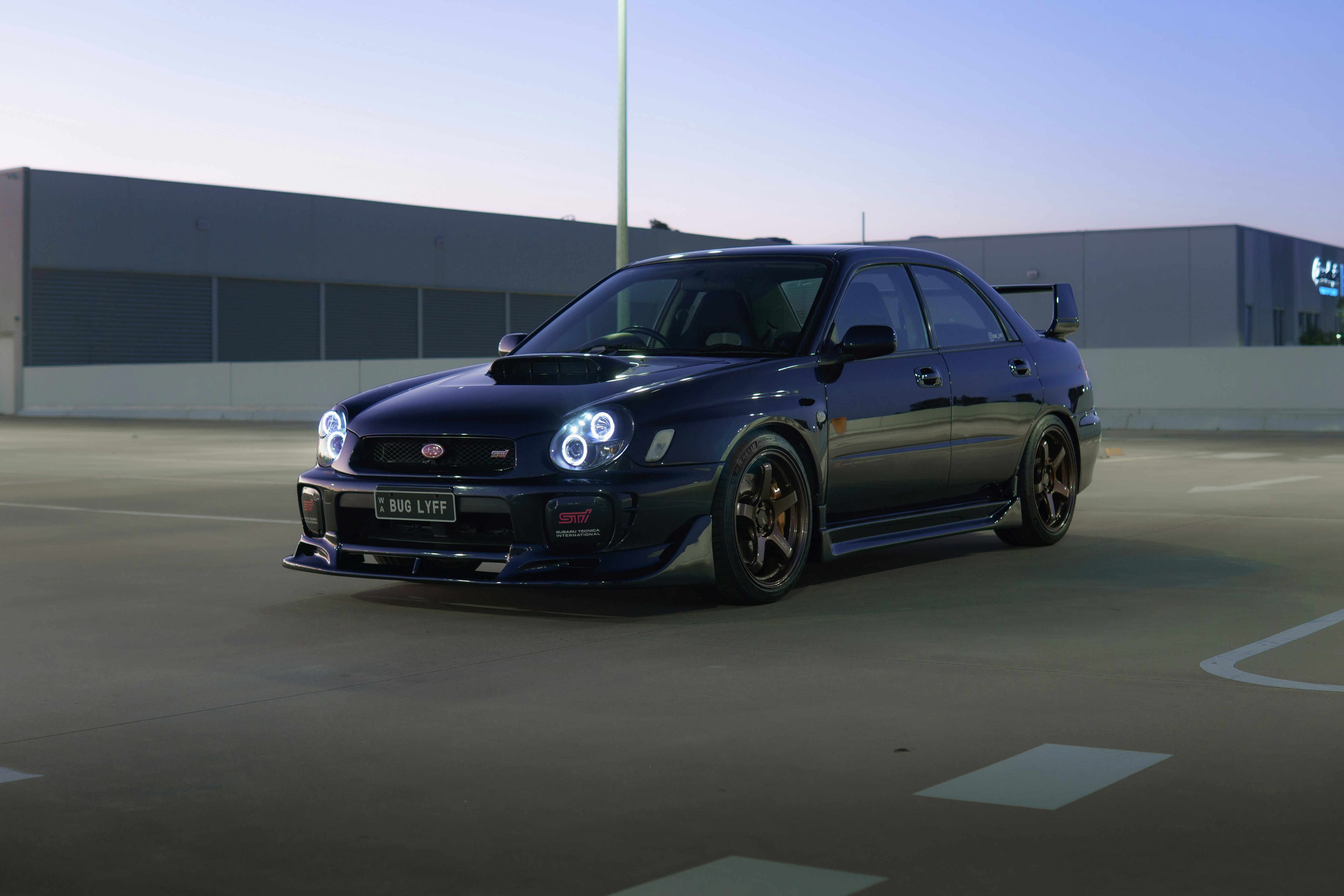 Midnight Performer: A Sleek Sedan Resting Under Parking Lot Lights