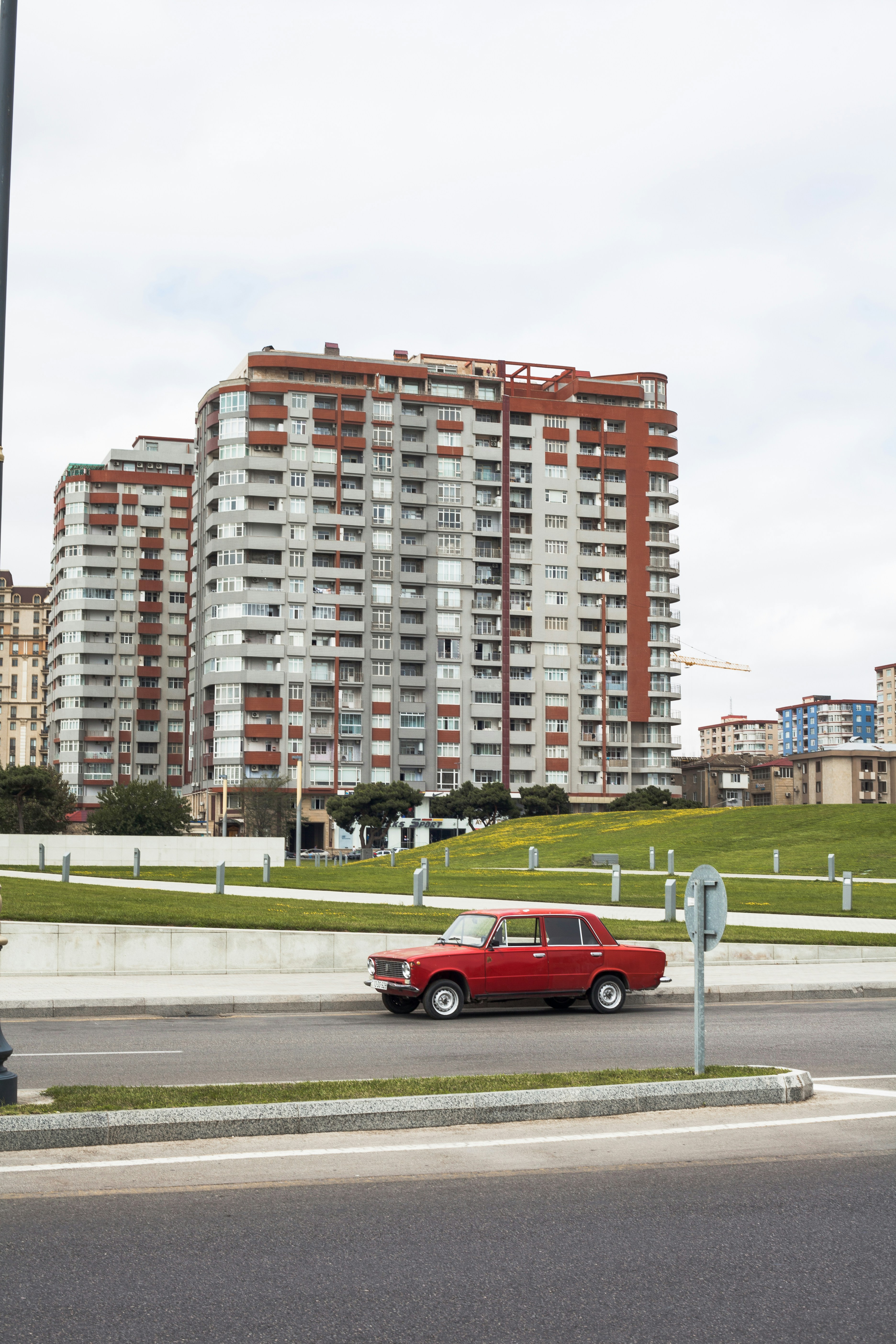 Red Classic on the Boulevard: A Striking Red Pickup Amid Modern High-Rolds