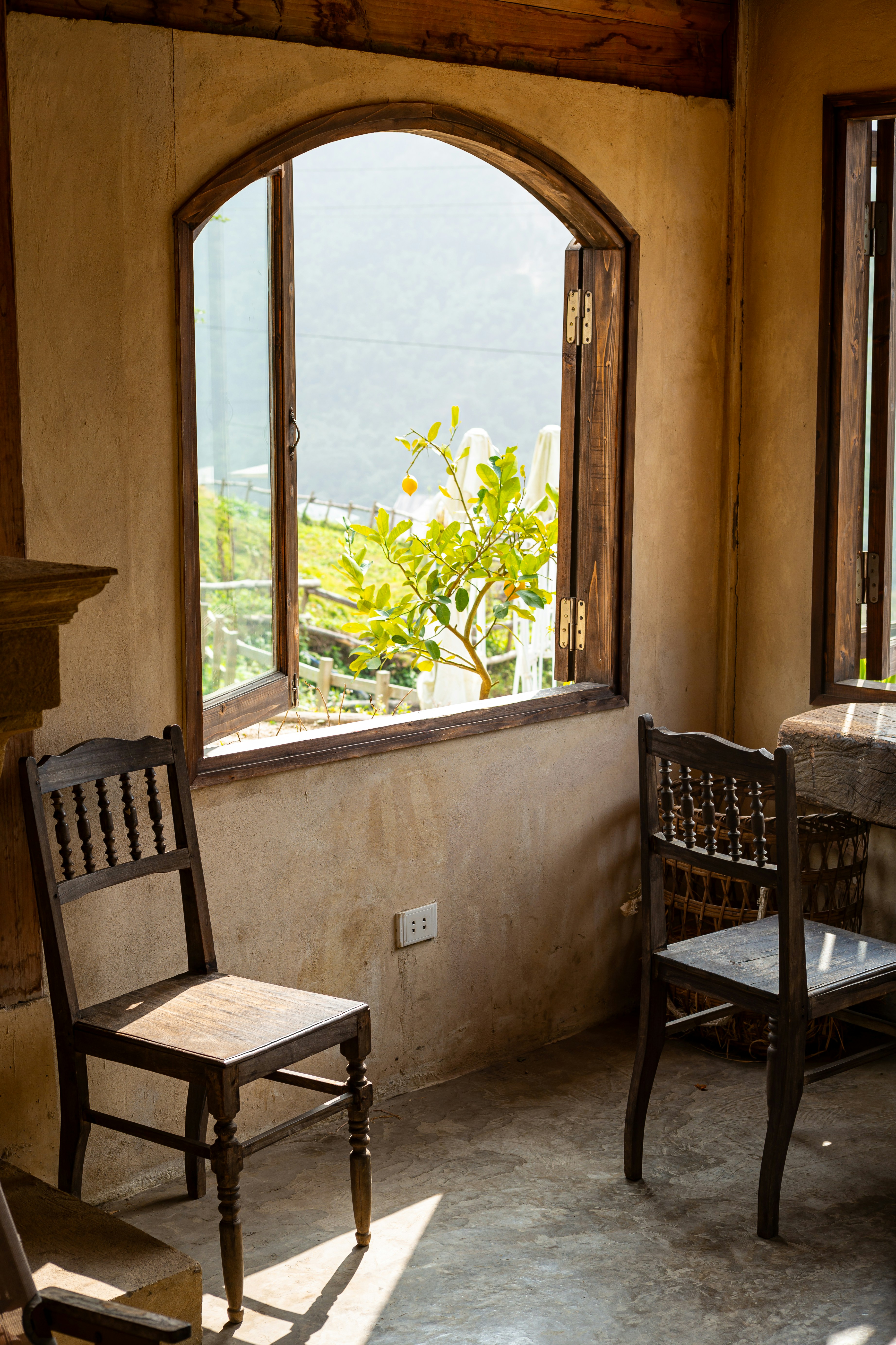Sunlit Balcony View Tucked Through an Old Window